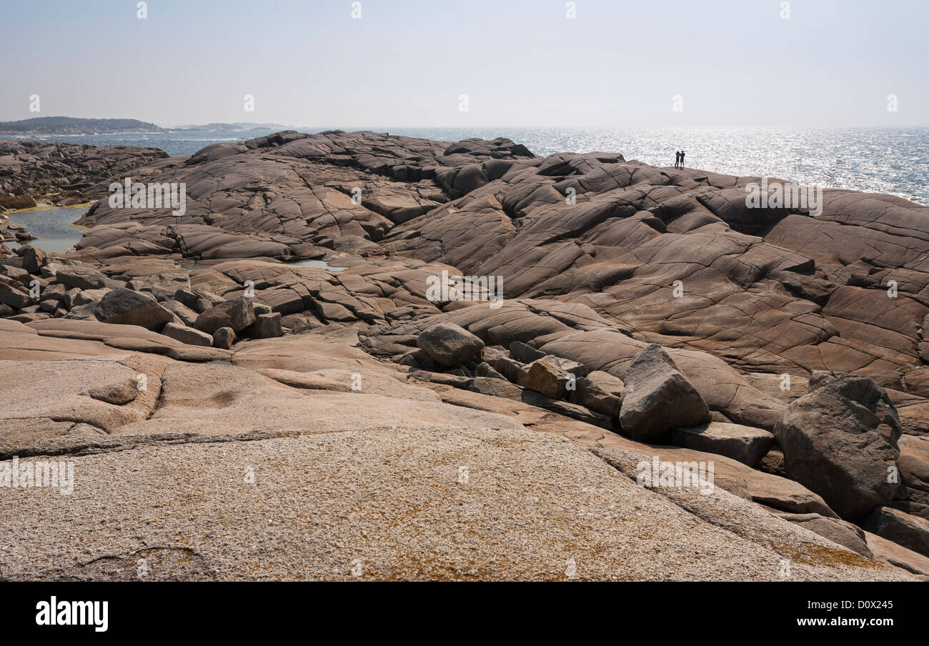 Enjoying the view of Peggy's Cove. A couple far out on the rocks that ...