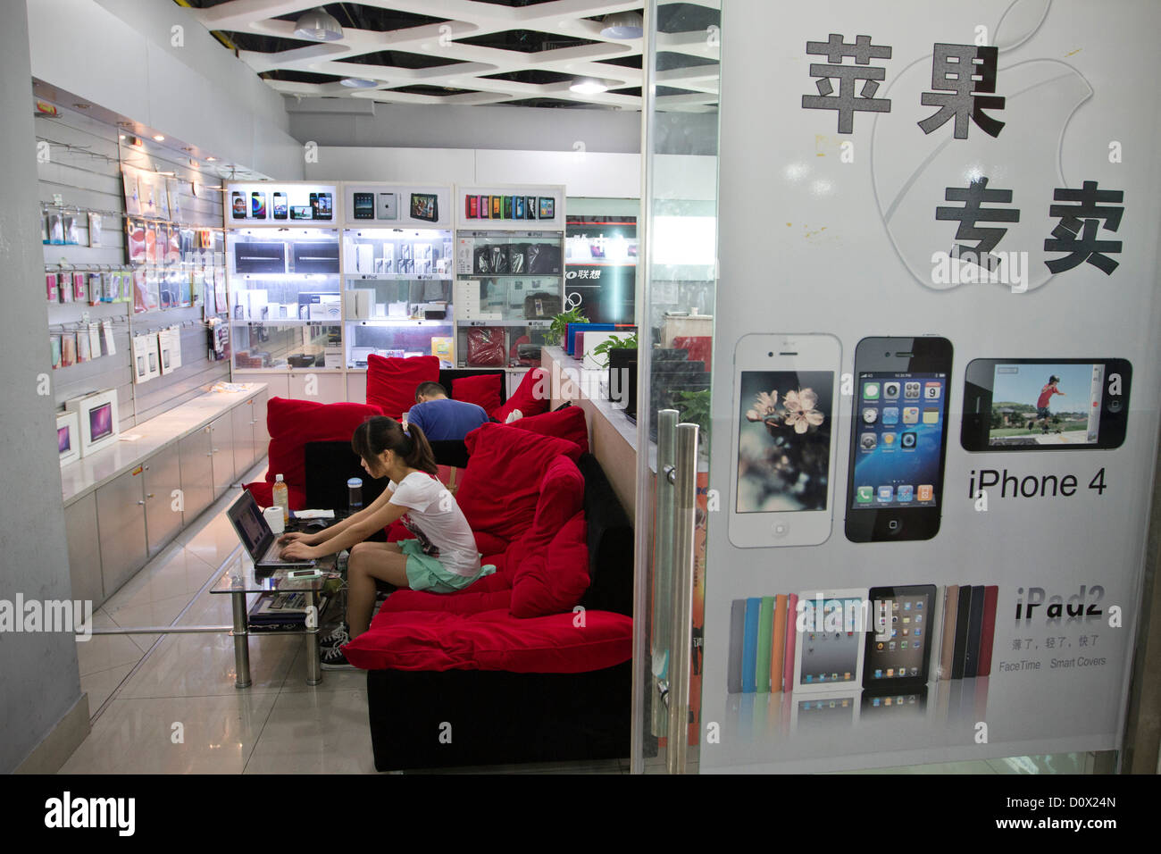 A female customer using a laptop computer at a retail unit housed ...