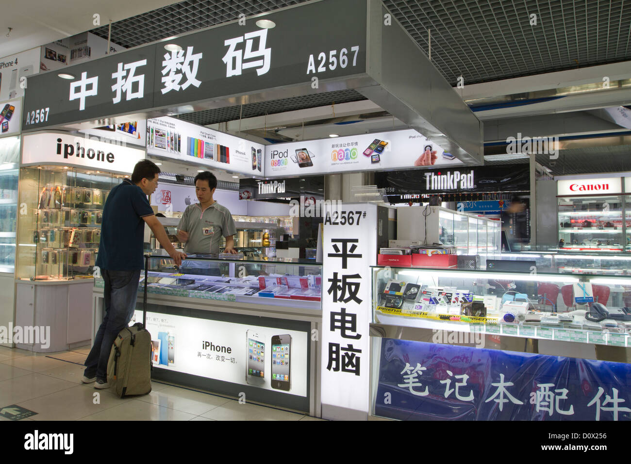 A customer talking to a member of staff at a retail unit at a mall ...