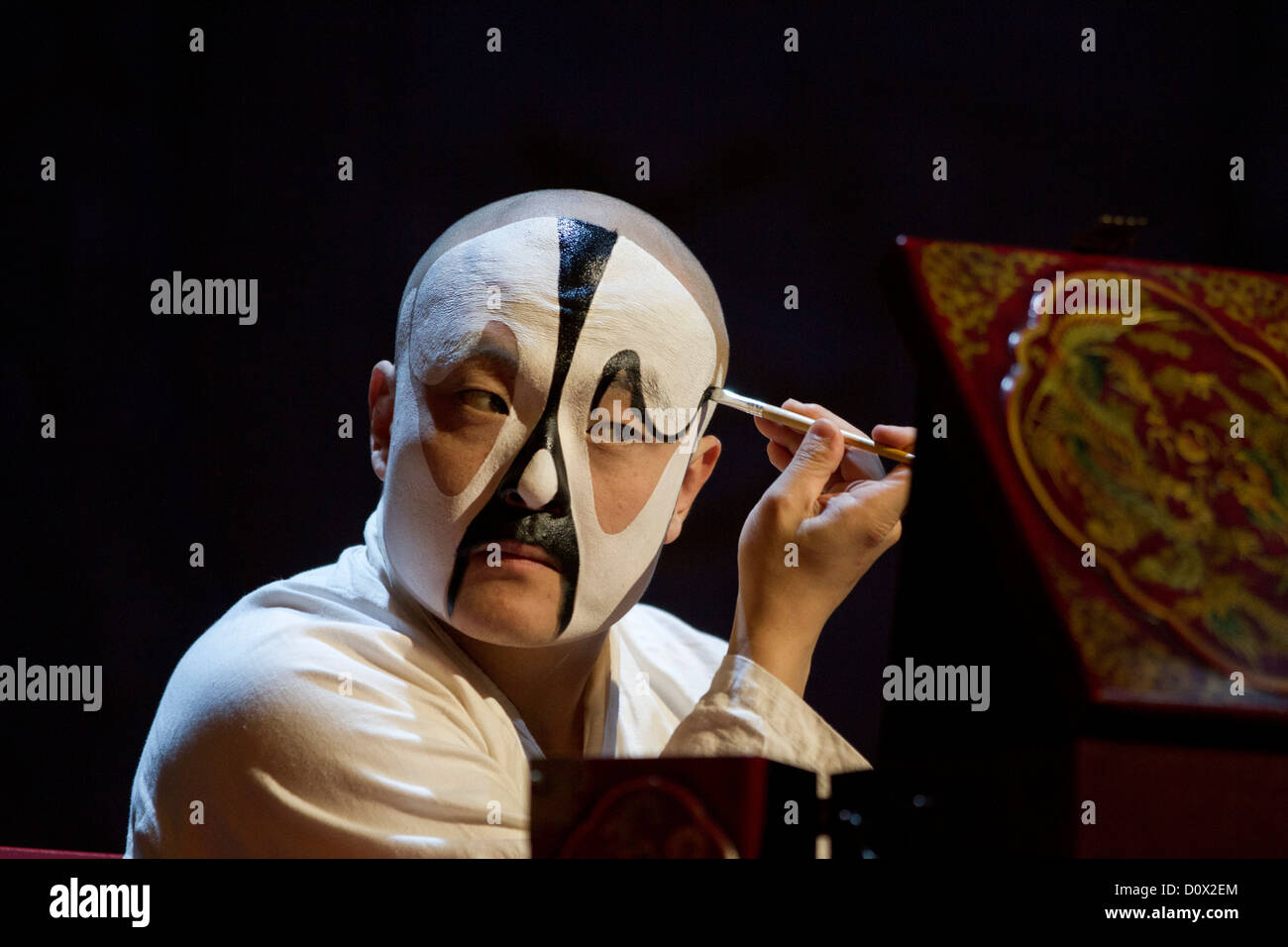 A male lead character applying make-up to his face prior to a ...