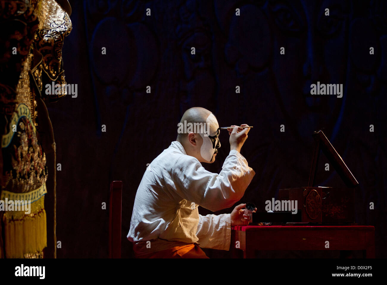 A male lead character applying make-up to his face prior to a ...