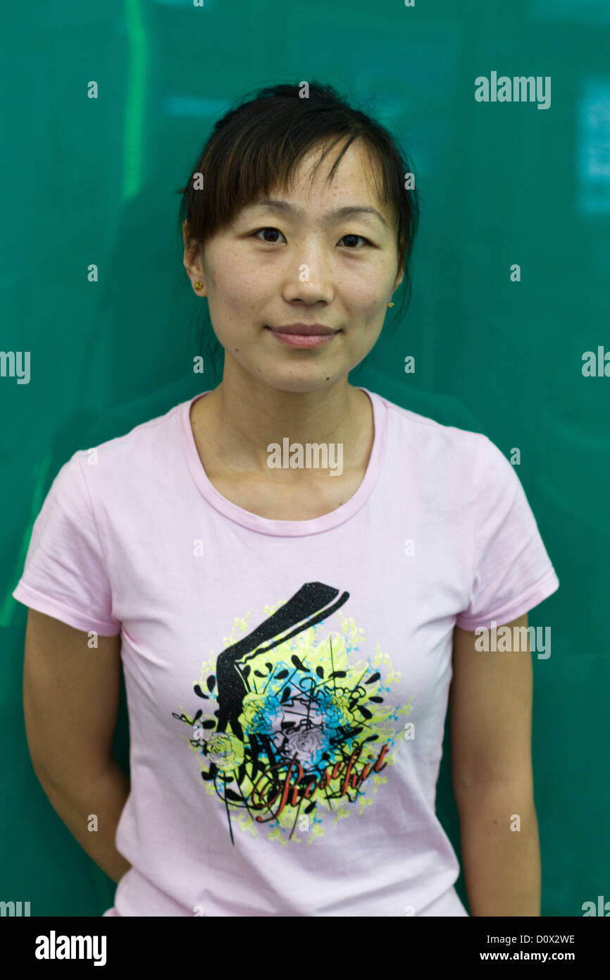 A young Chinese female wearing a pink t-shirt with a motif ...
