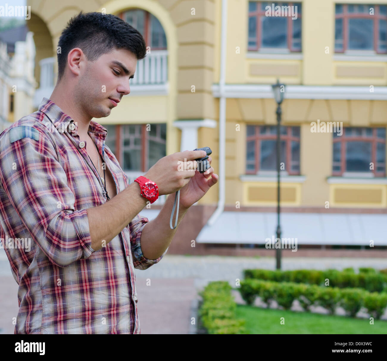 Man checking the viewfinder at the back of a camera to check the ...