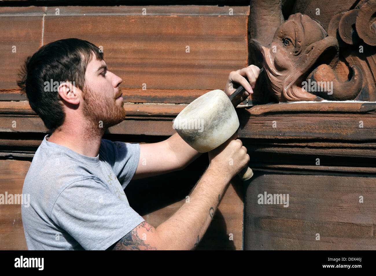 David Carty, a stone carver, repairing the damaged sandstone carving on ...