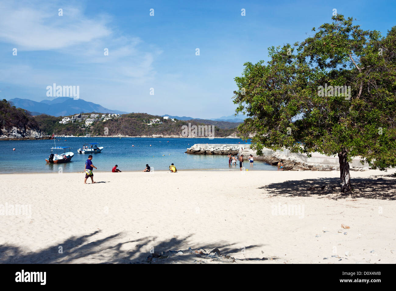 people enjoying the pristine white sand beach & translucent blue sea in ...