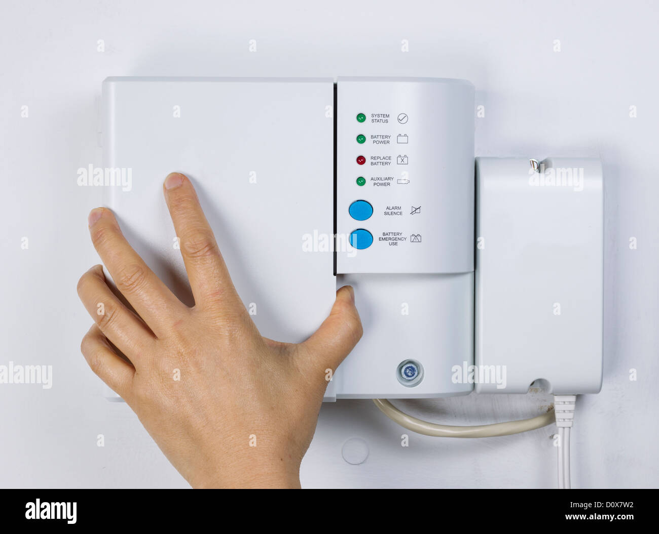 Female hand opening up battery pack panel on garage wall outlet Stock ...