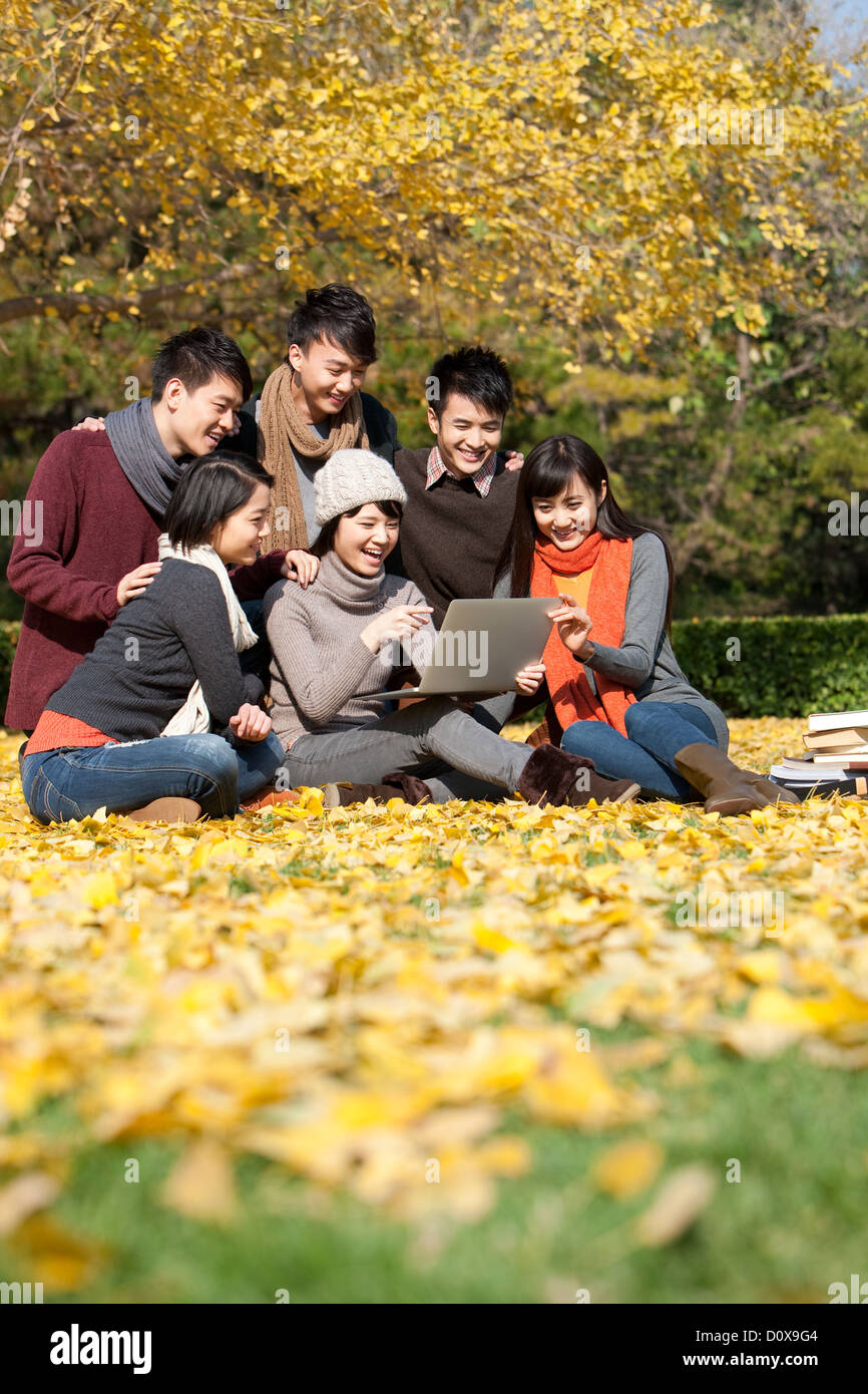 Cheerful college students with laptop and books on campus in a ...