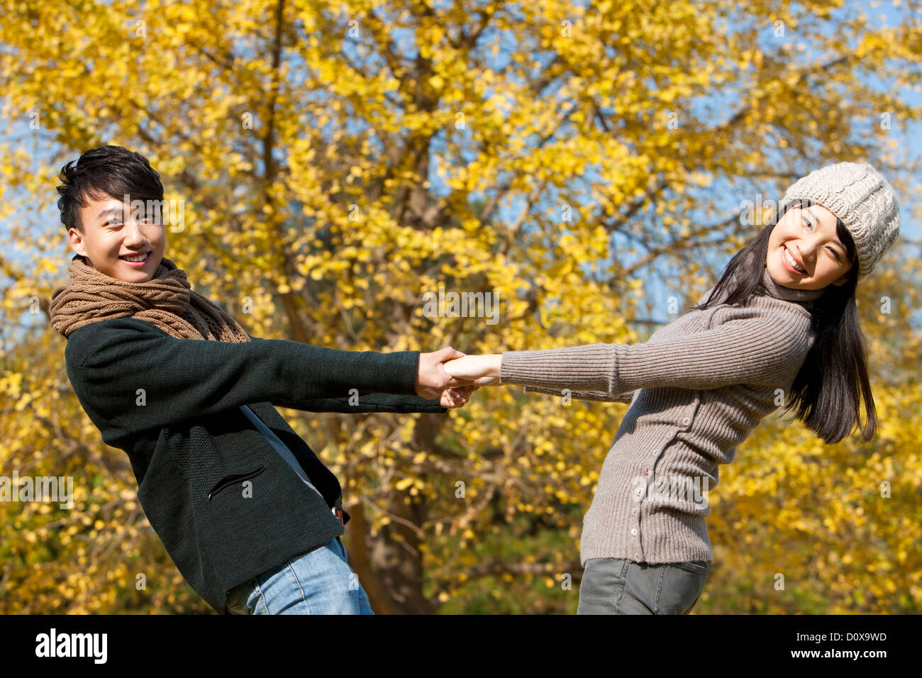 Happy young couple in love holding hands outdoors in autumn Stock Photo - Alamy