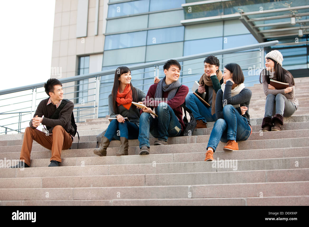 Young college students sitting on steps of university building Stock ...