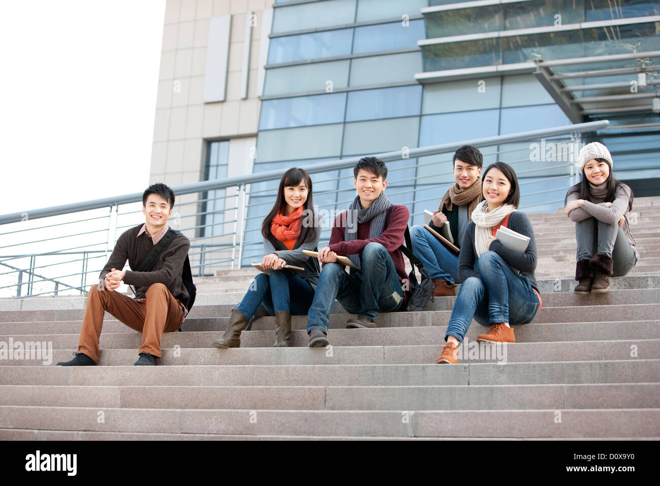 Young college students sitting on steps of university building Stock ...