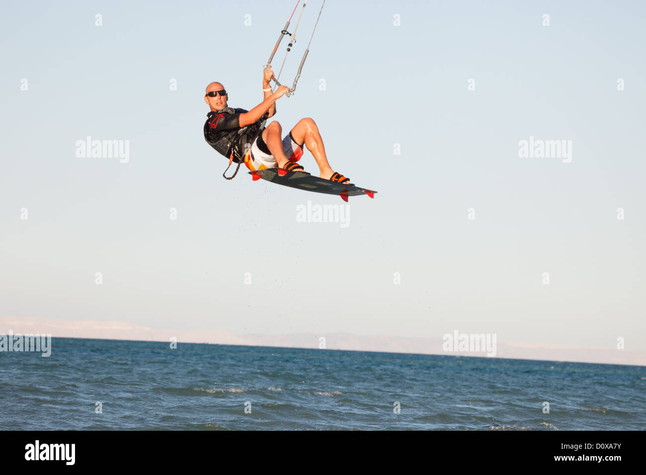 Kiteboarder enjoy surfing in blue water and jumps high in the air Stock ...