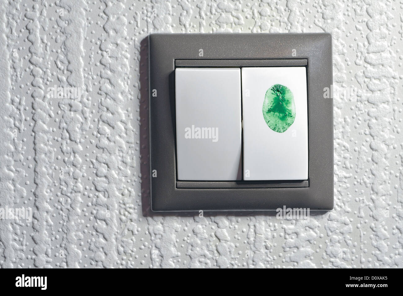 two keys light switch, one is touched by green color fingertip to ...