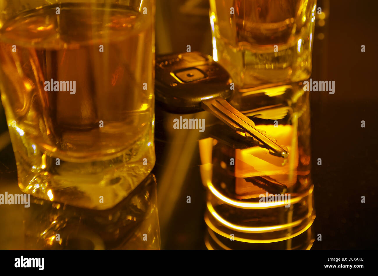 two whiskey shots on the bar shelf with car key between them; focus on ...