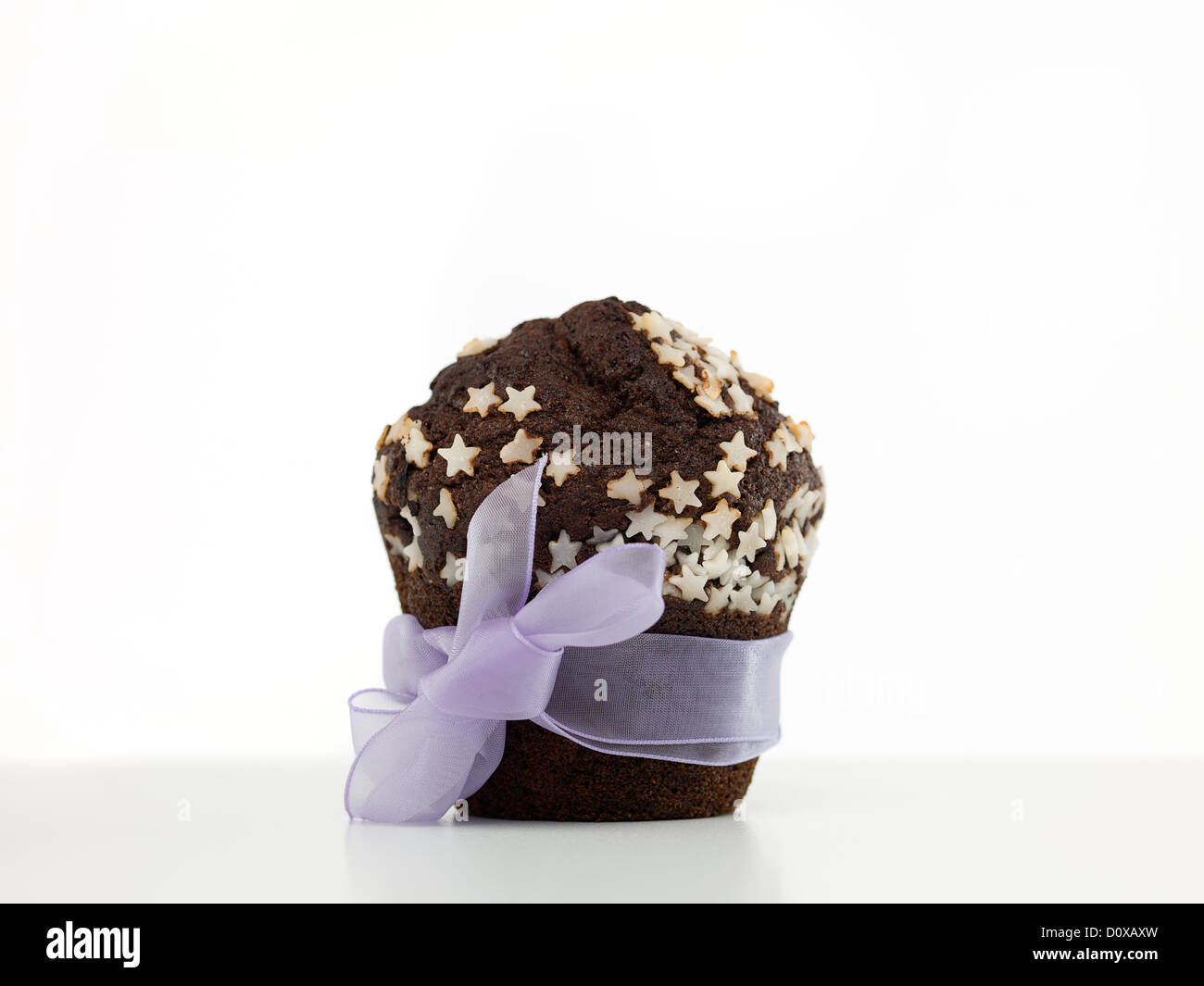 single chocolate muffin, decorated with white sugar stars, wrapped in ...