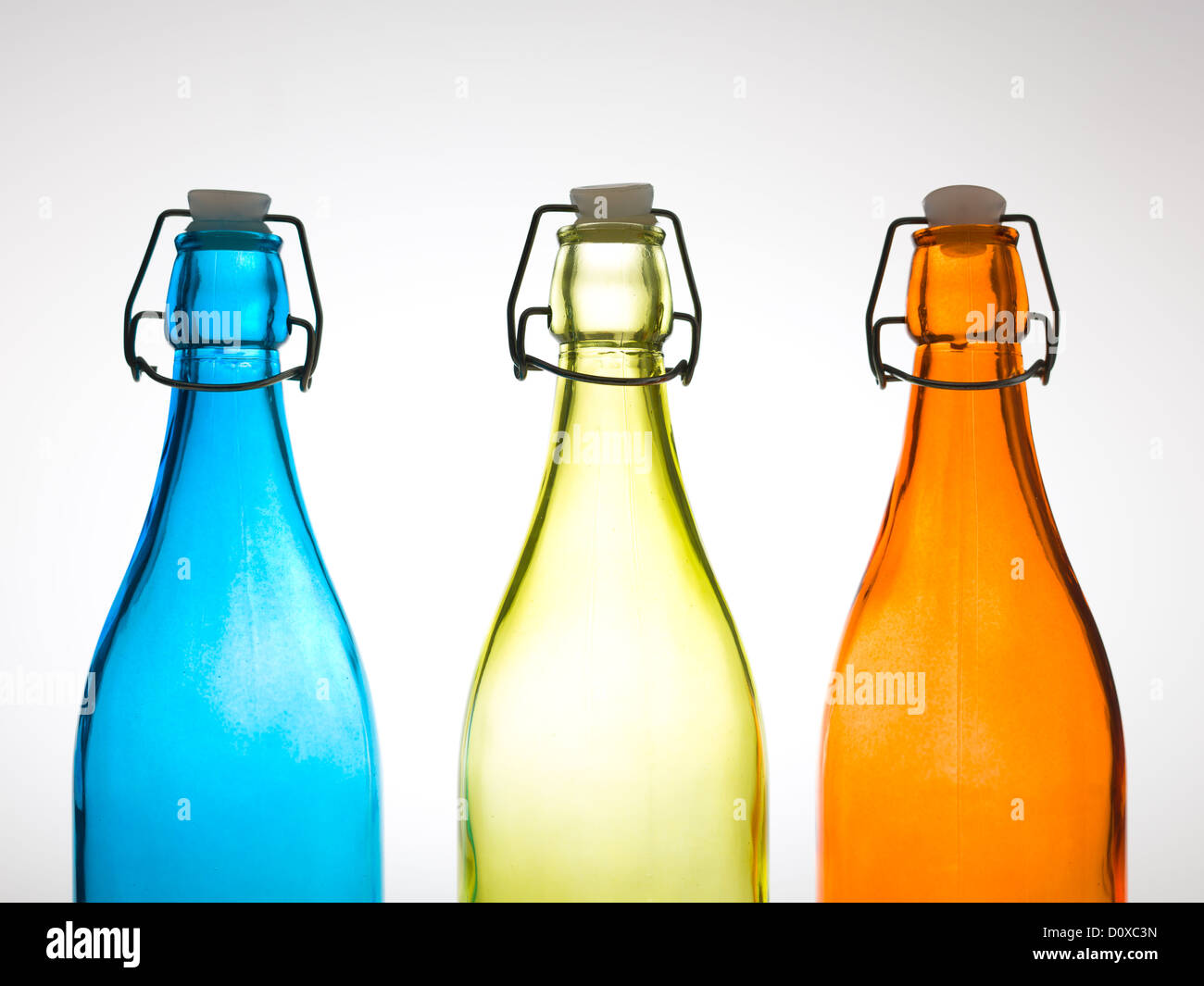 three colorful bottles blue green and orange with neutral gradient ...