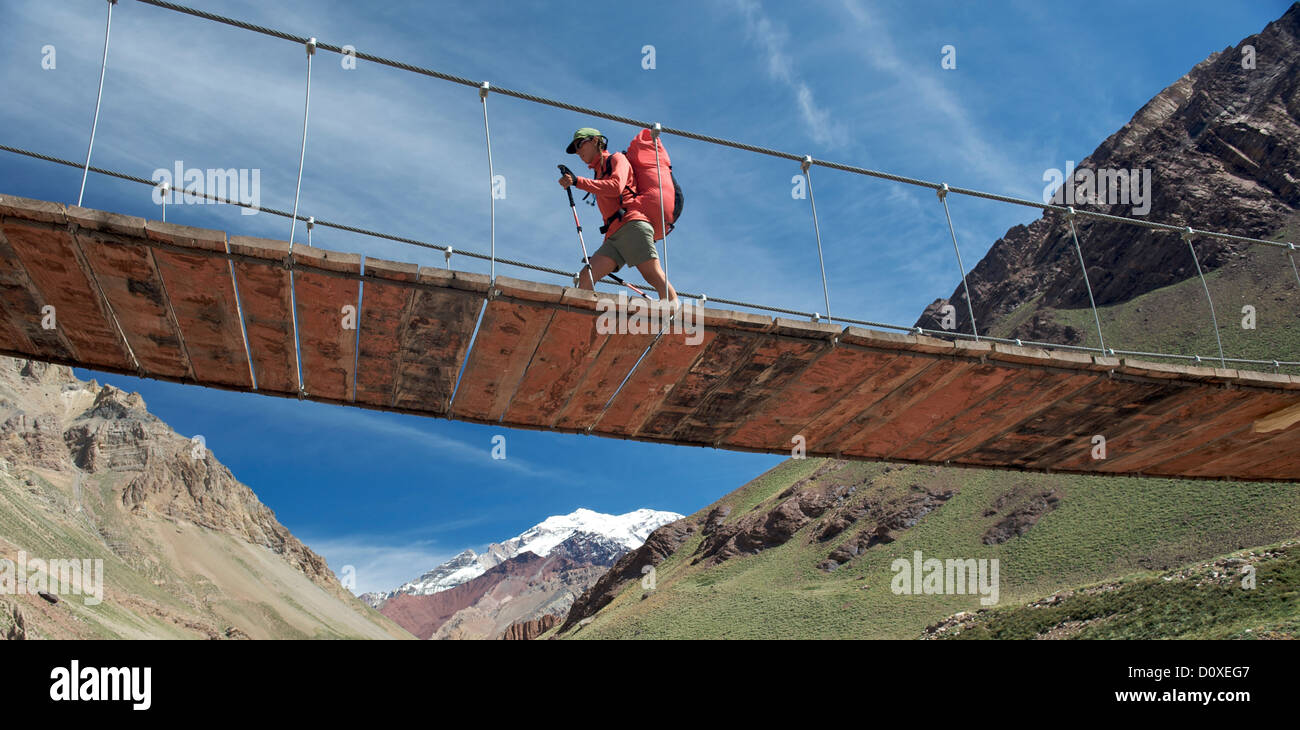 Woman crosses bridge over the Horcones River, Aconcagua in the Andes ...