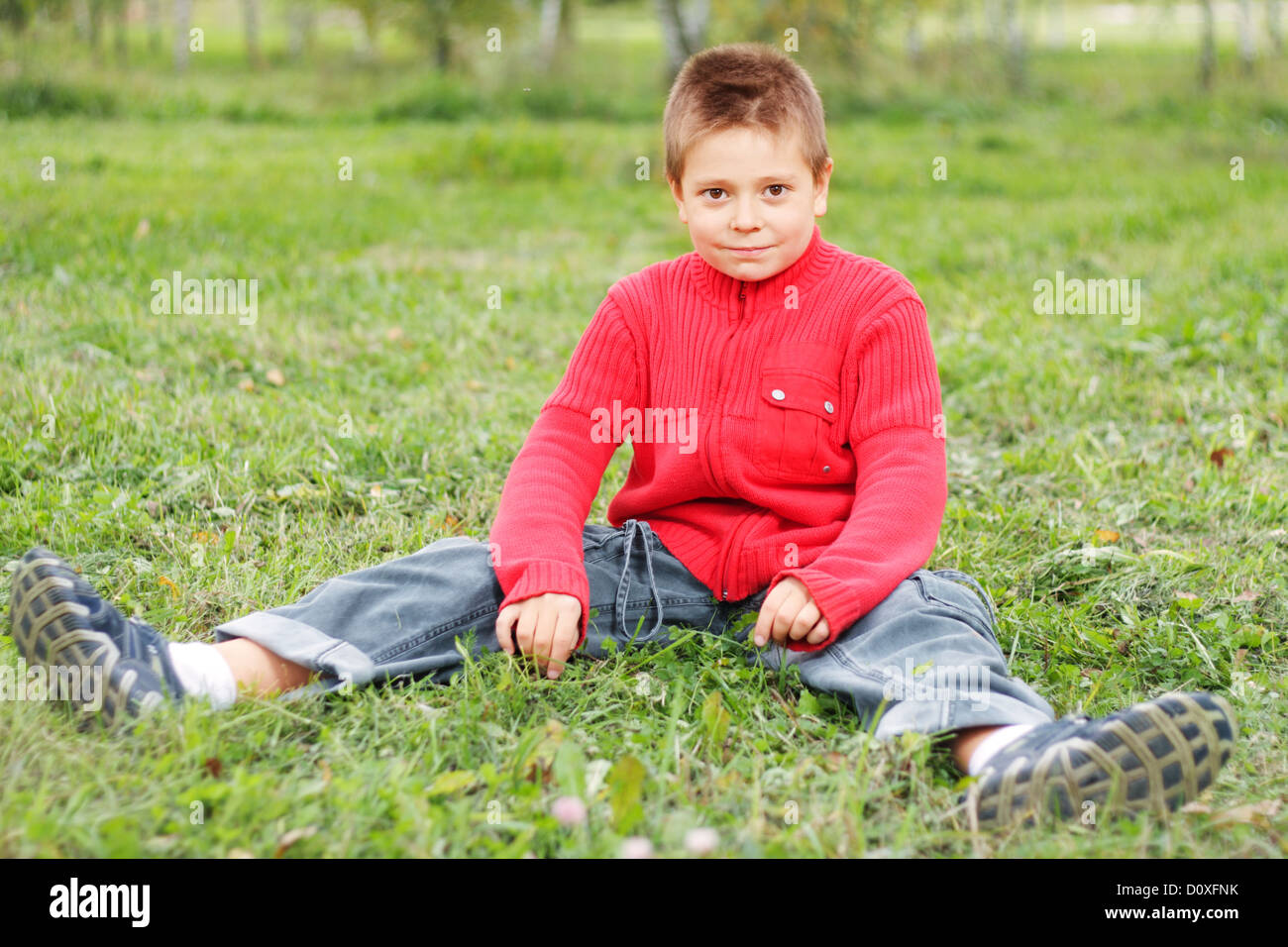 Boy sitting on grass Stock Photo - Alamy