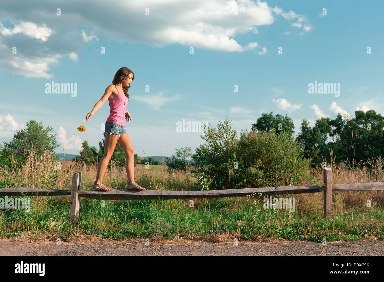 Teenage girl balancing on wooden fence Stock Photo - Alamy