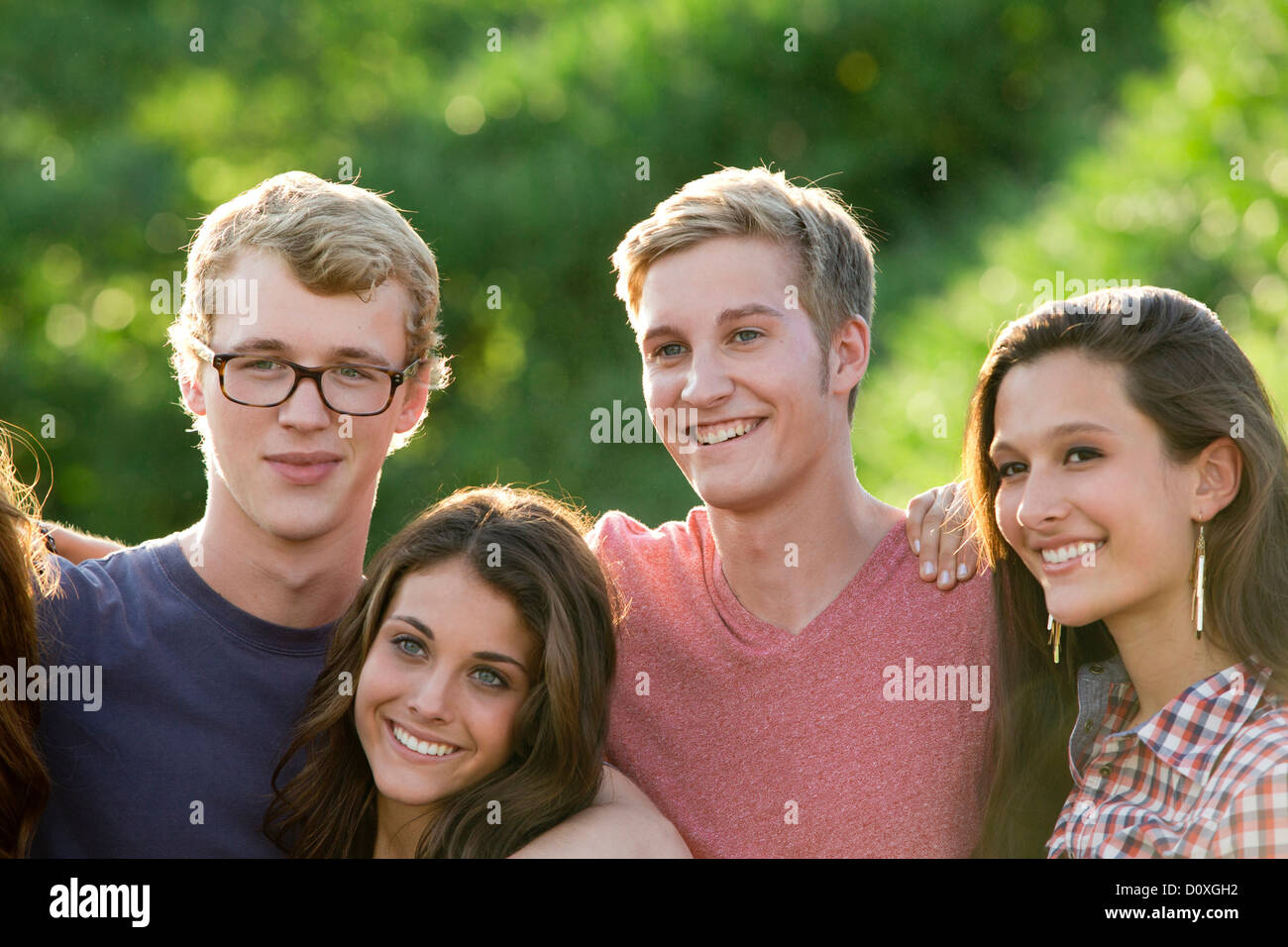 Portrait of four friends with arms around each other Stock Photo - Alamy