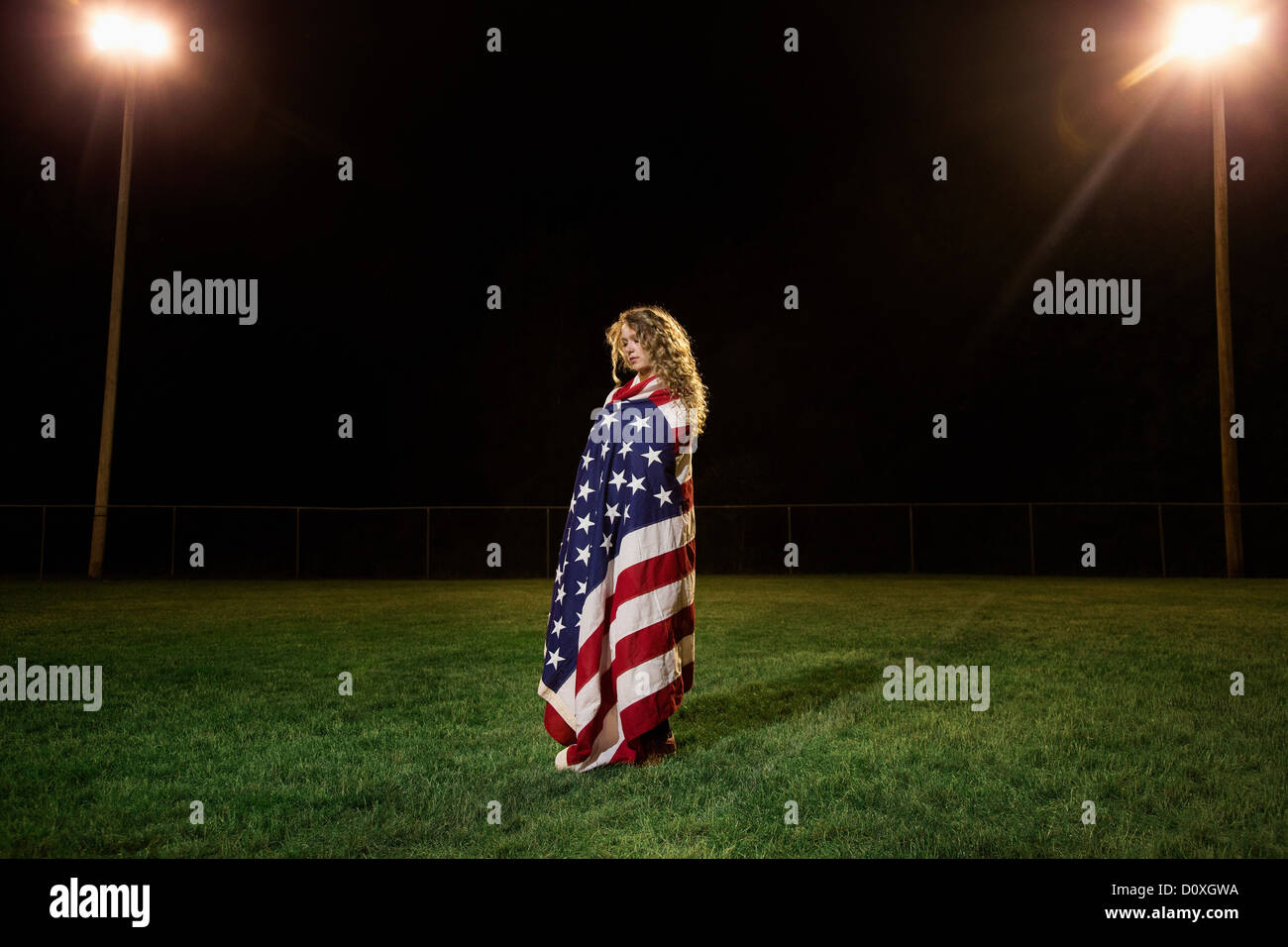 Girl wrapped in american flag at night Stock Photo - Alamy