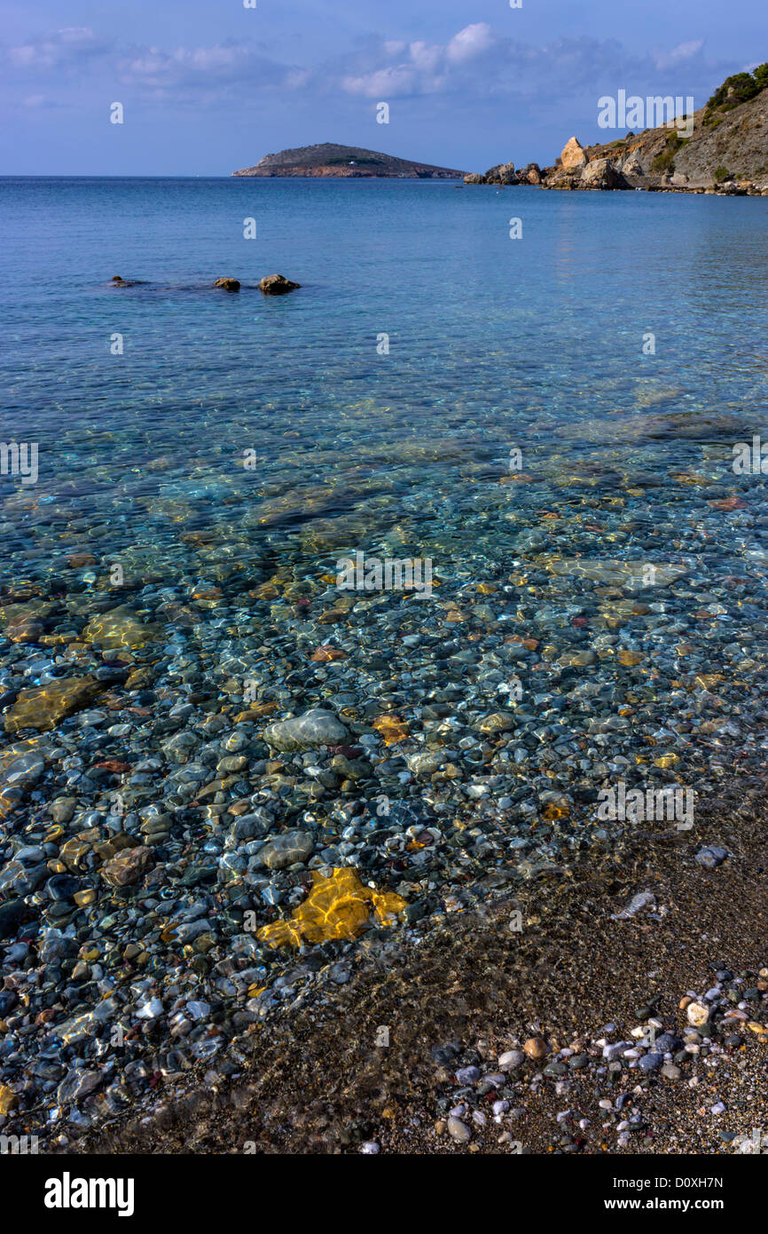 Clear blue sea, pebbles and rocks distant islands Stock Photo - Alamy