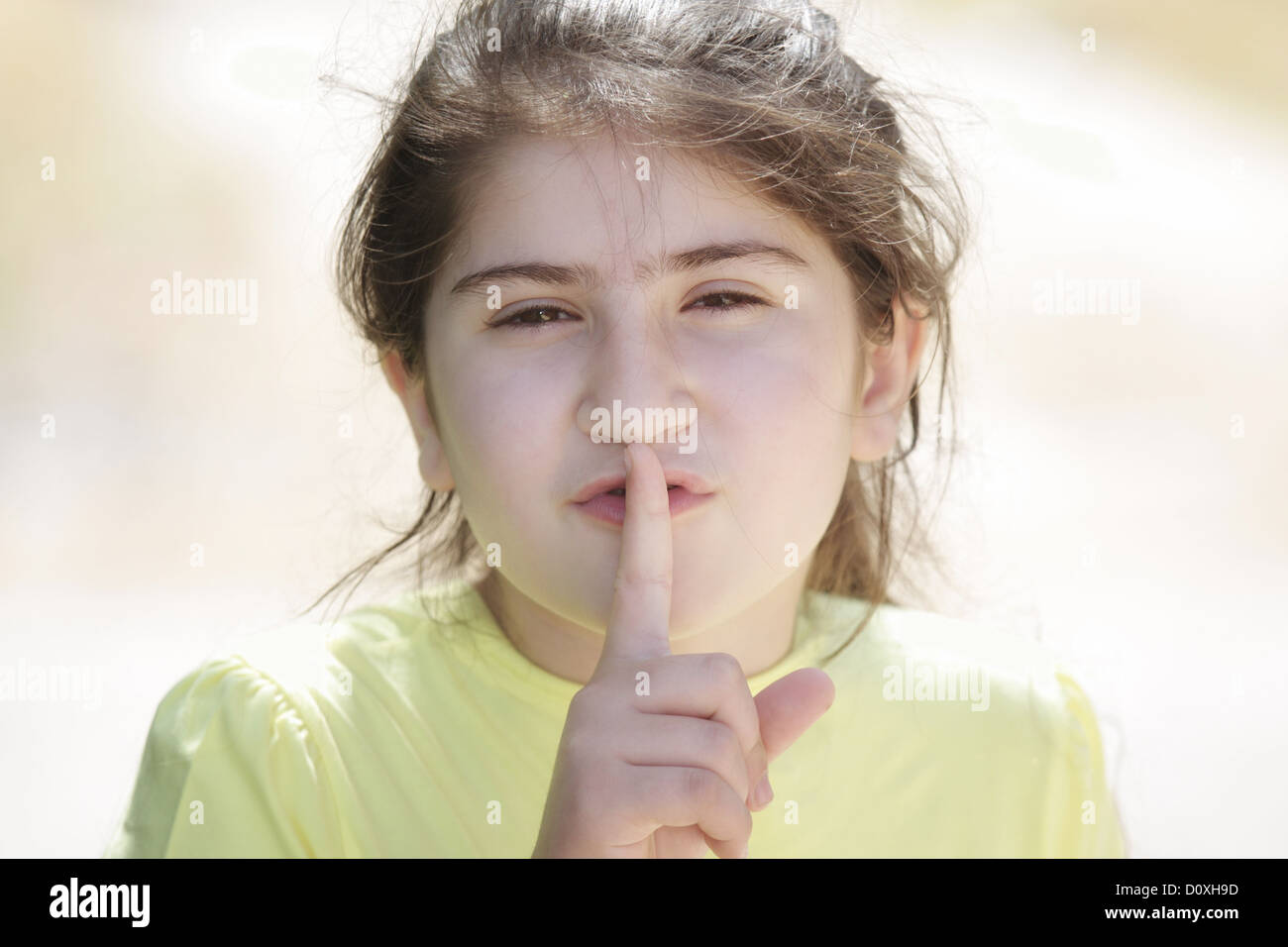 Brunette girl gesturing hush Stock Photo - Alamy