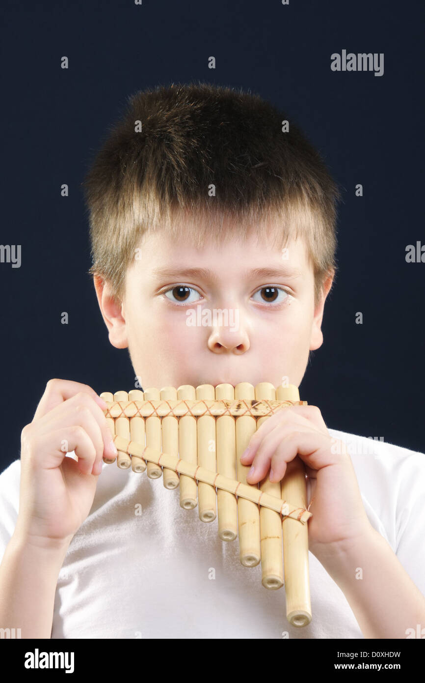 Boy in white playing panflute Stock Photo - Alamy