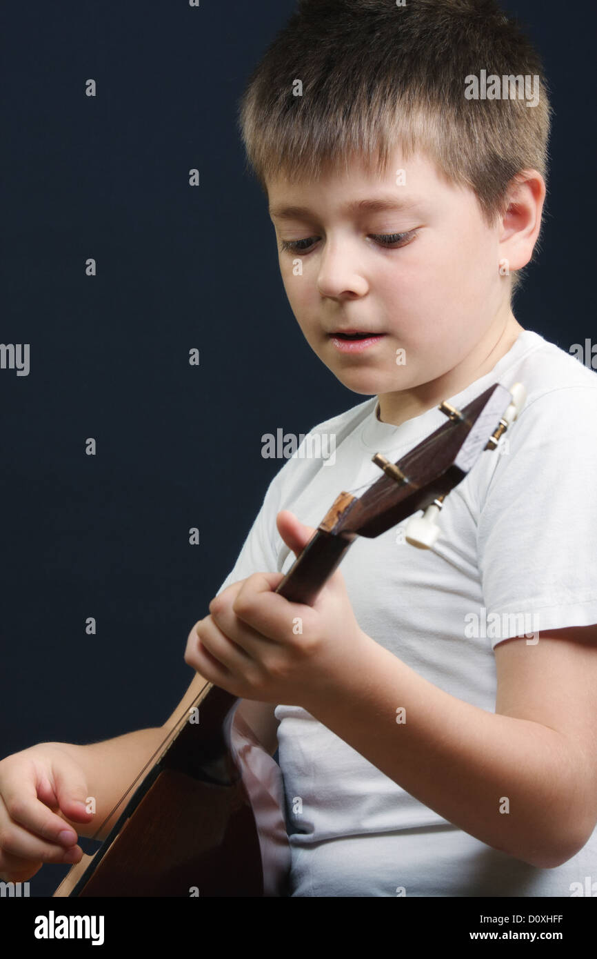 Boy in white playing balalaika Stock Photo - Alamy