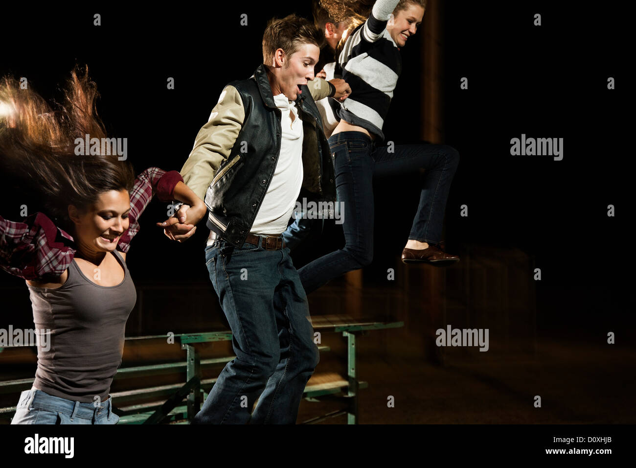 Teenage boy jumping over friends hi-res stock photography and images ...
