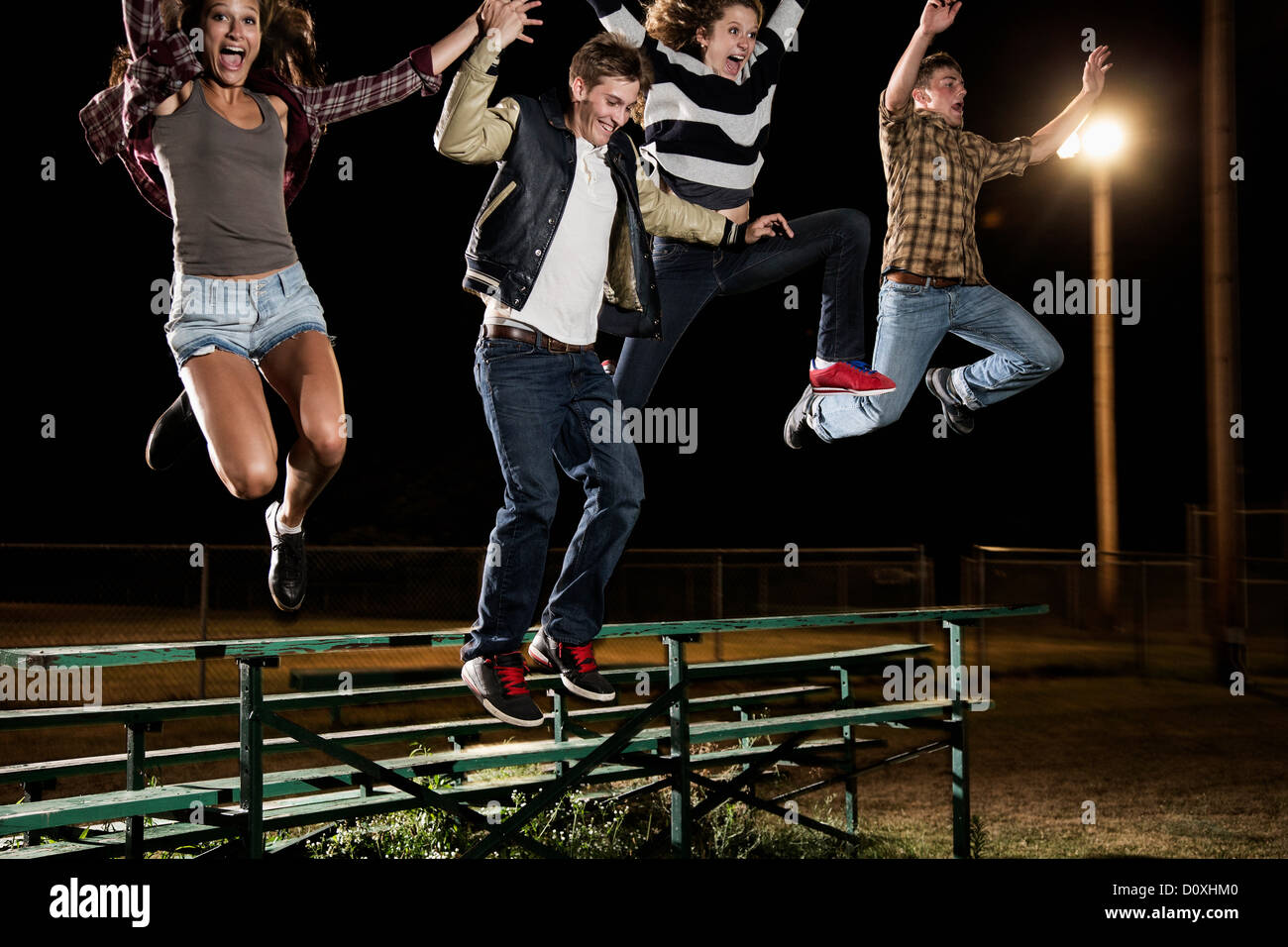 Teenage boy jumping over friends hi-res stock photography and images ...