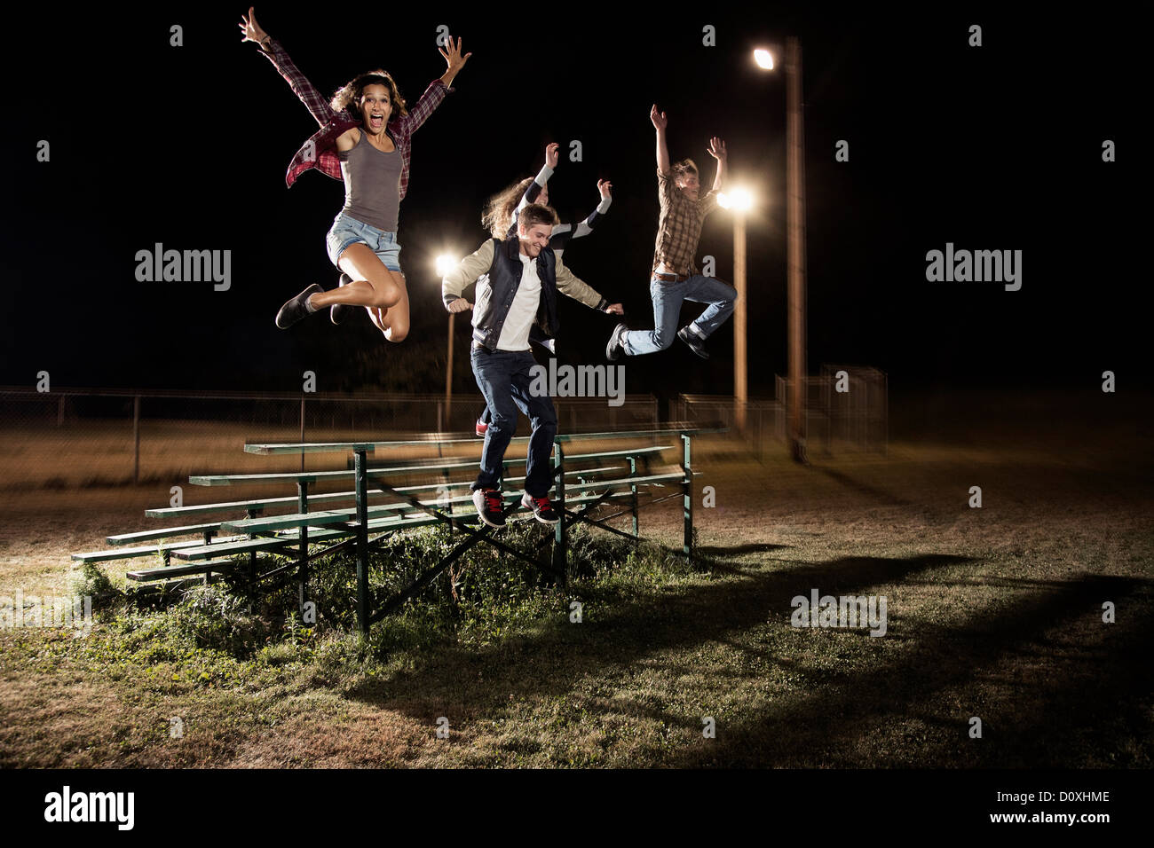 Teenage boy jumping over friends hi-res stock photography and images ...