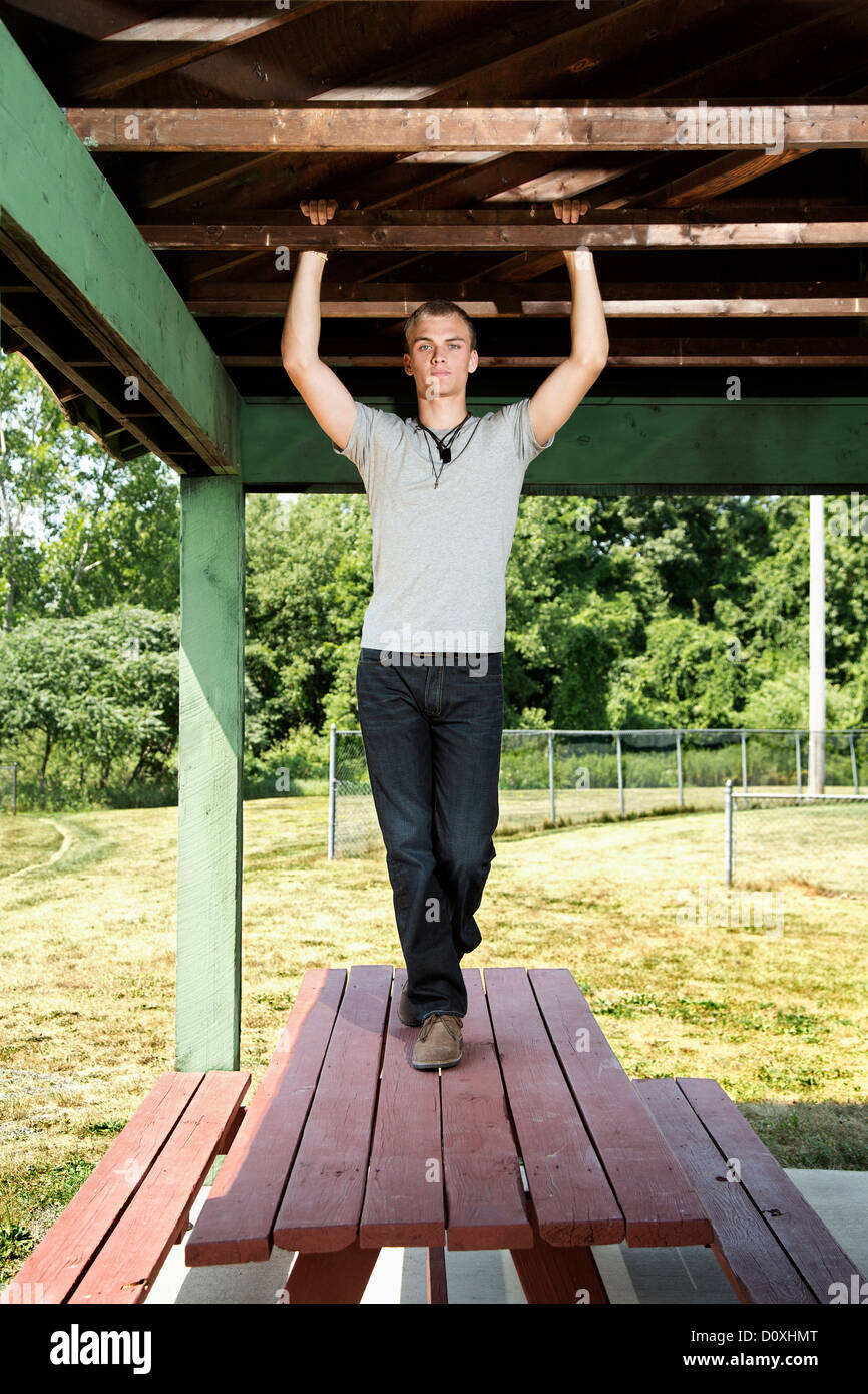 Portrait of young man standing on picnic table Stock Photo - Alamy