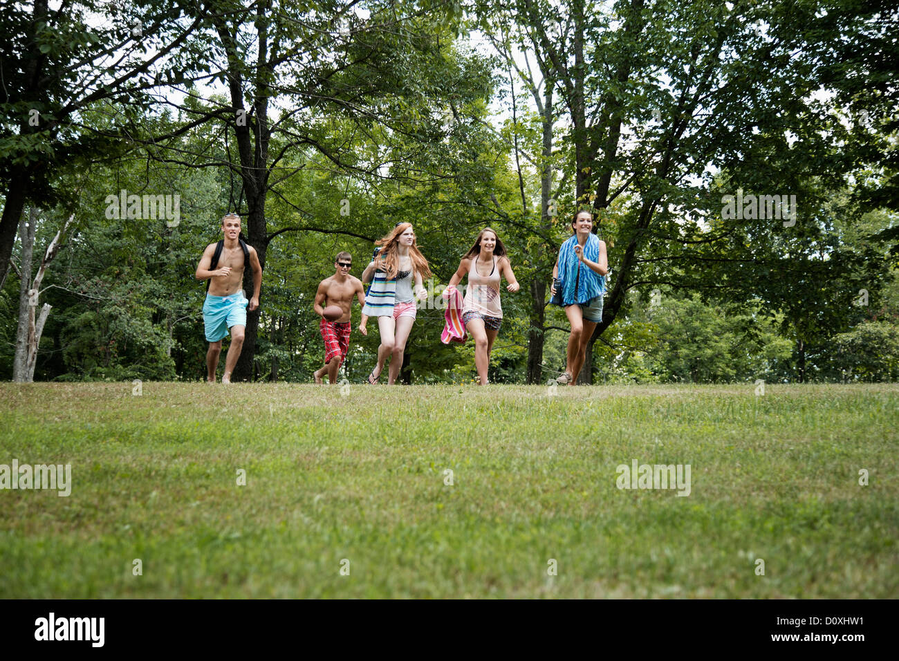 Five friends running on grass, front view Stock Photo - Alamy