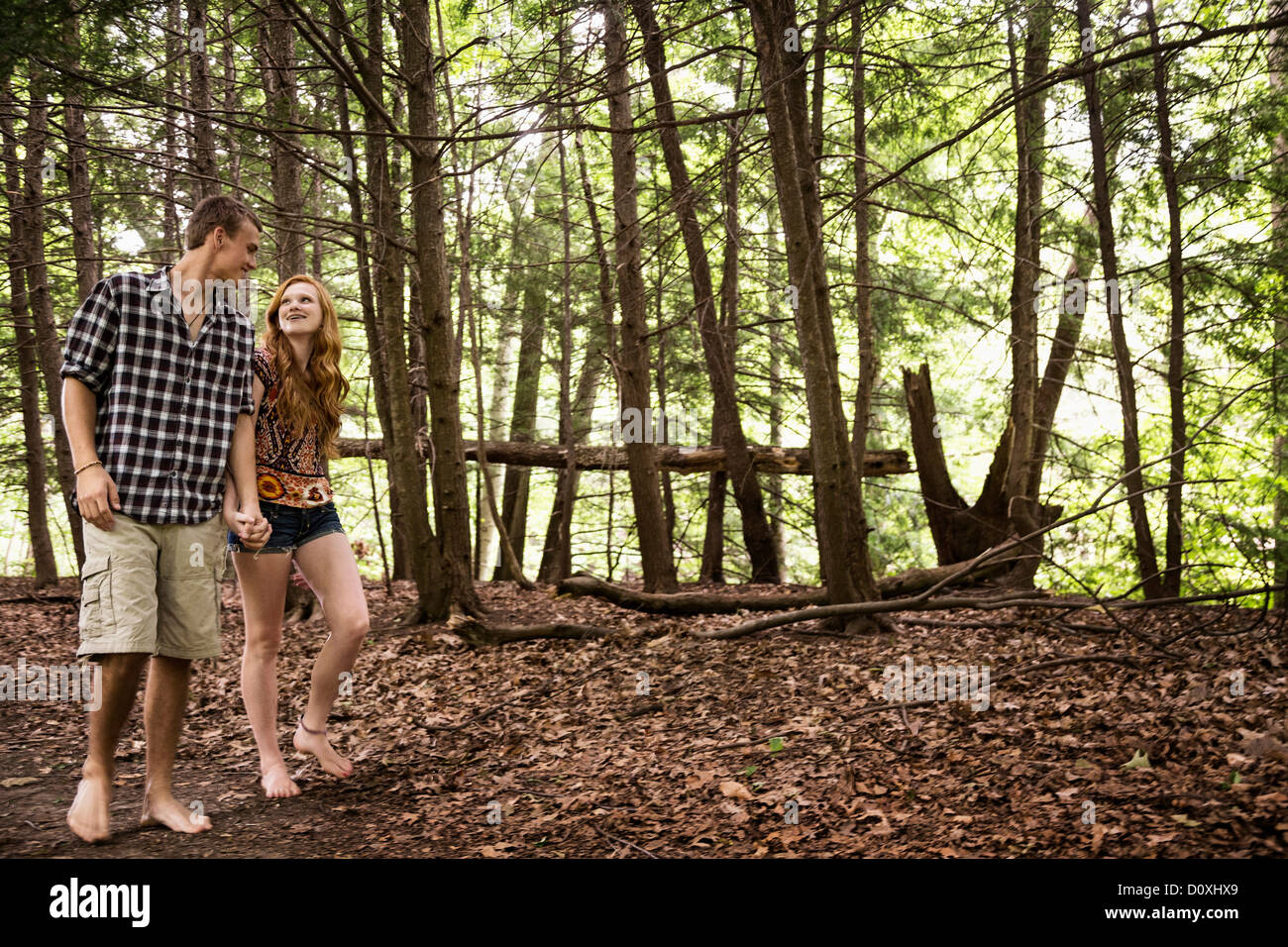Couple walking through forest Stock Photo - Alamy