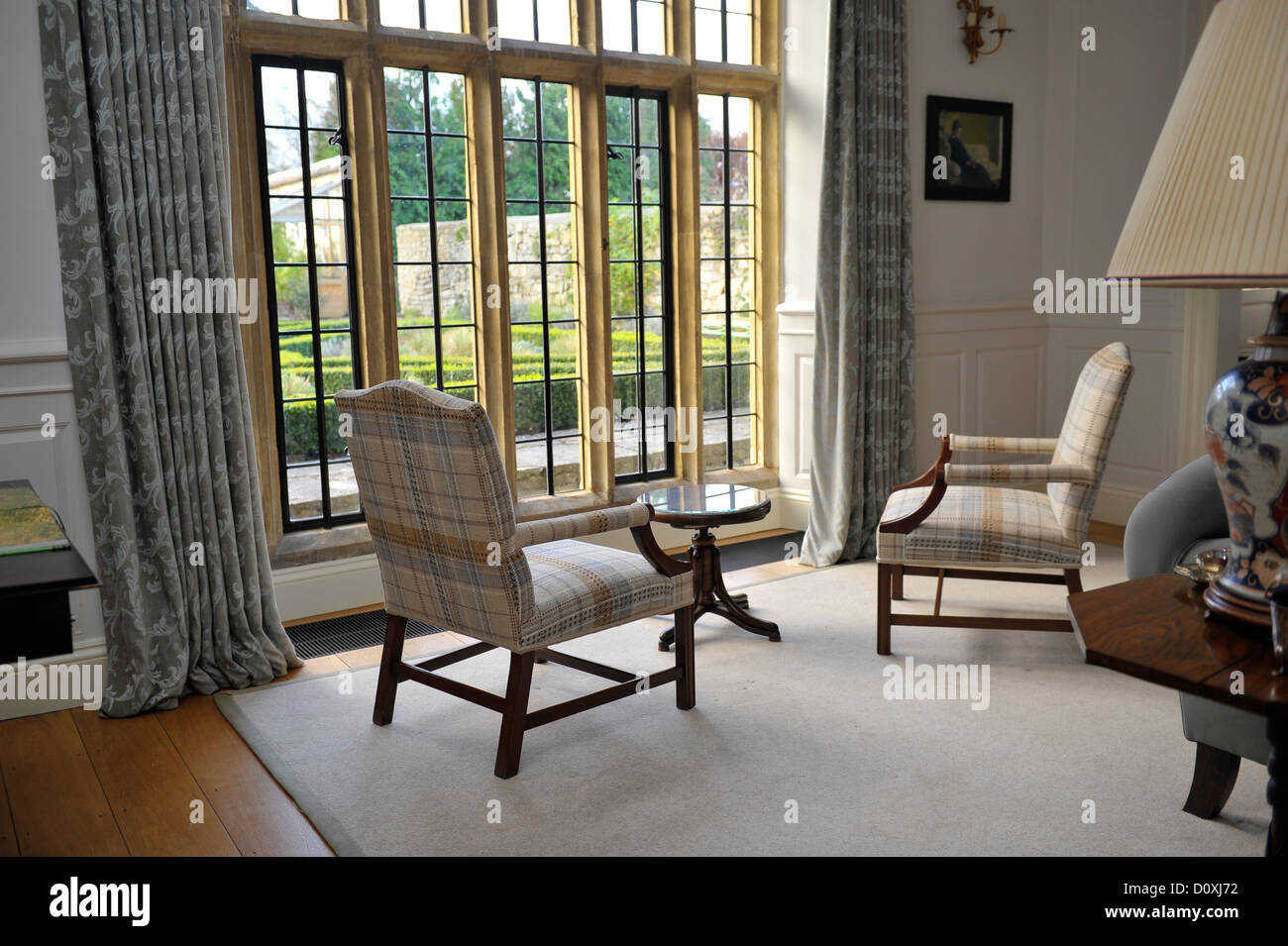 Lounge of country house UK with chairs facing mullioned window looking ...