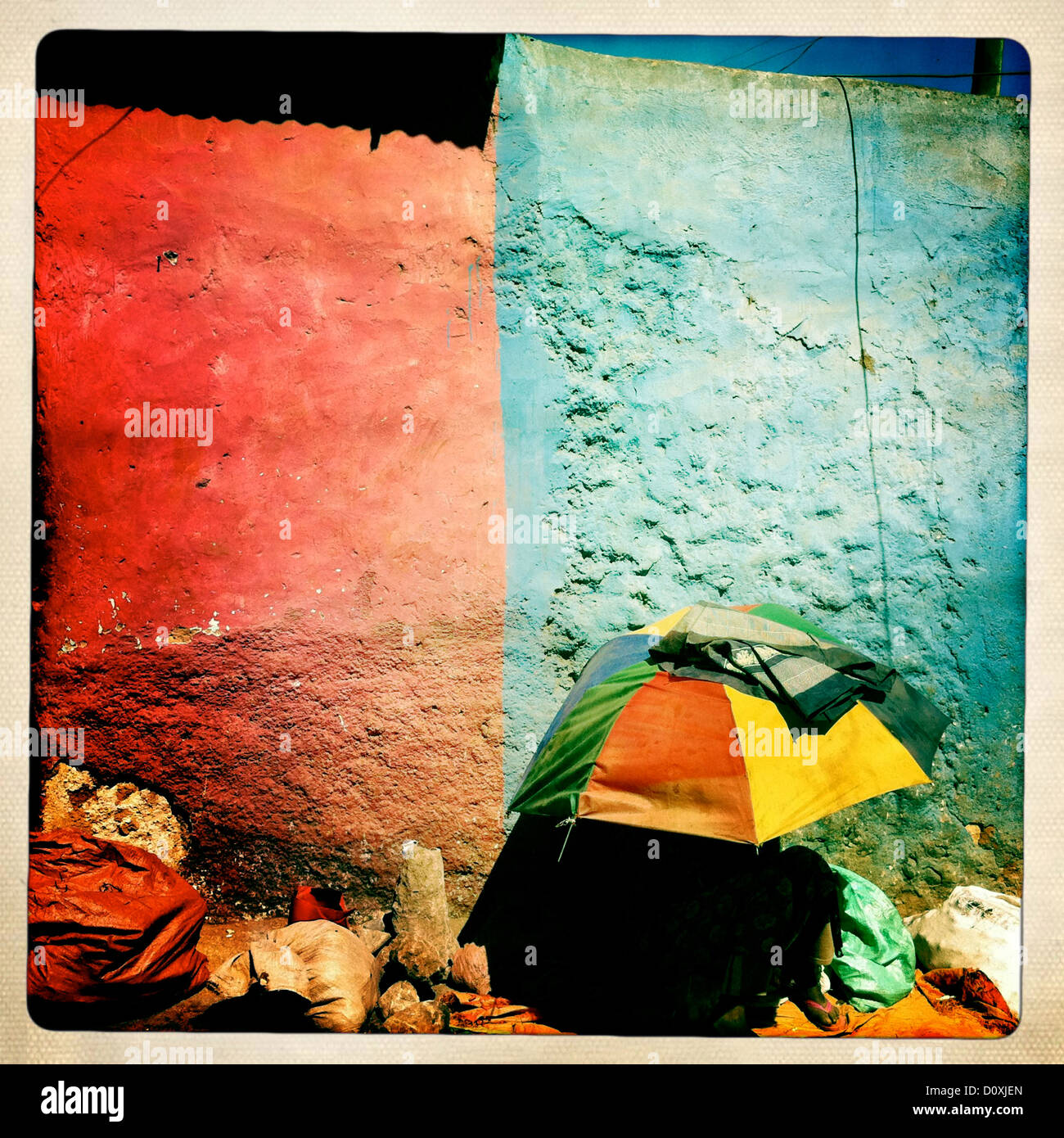 Person Hiding From The Sun Under A Colourful Umbrella And Painted Wall ...