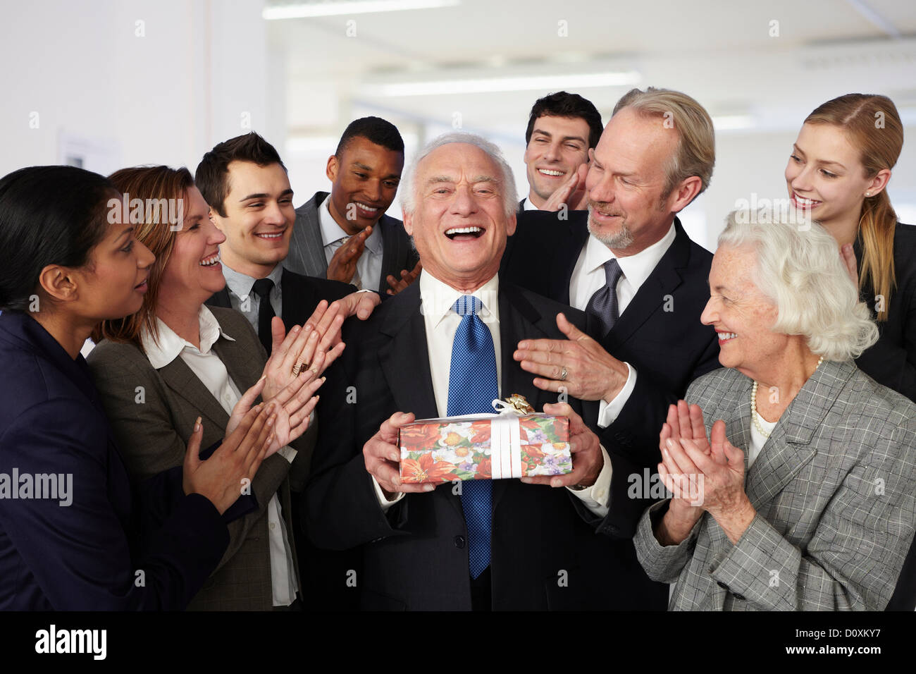 Colleagues giving gift to businessman Stock Photo - Alamy