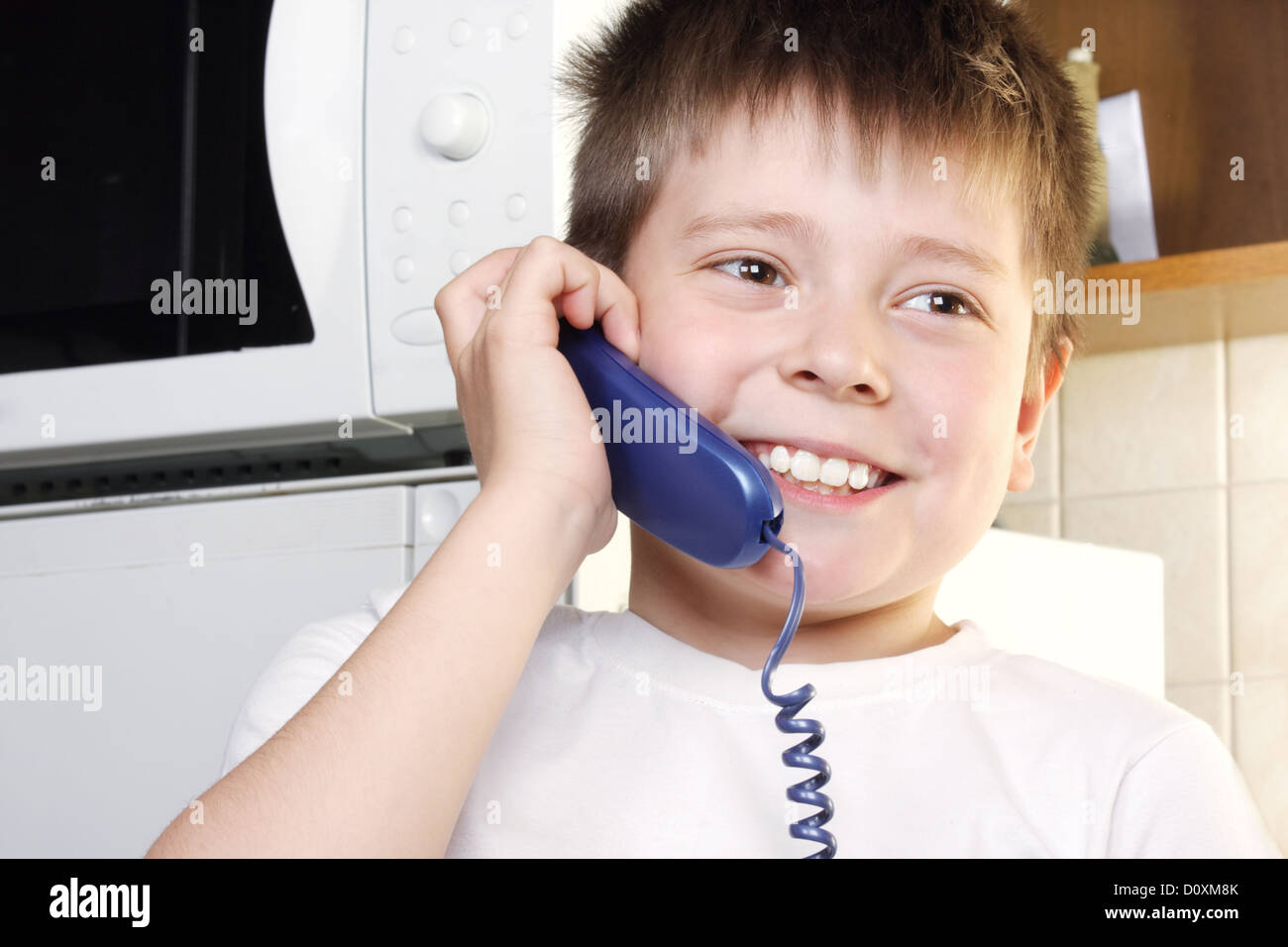 Boy in white talking phone Stock Photo - Alamy