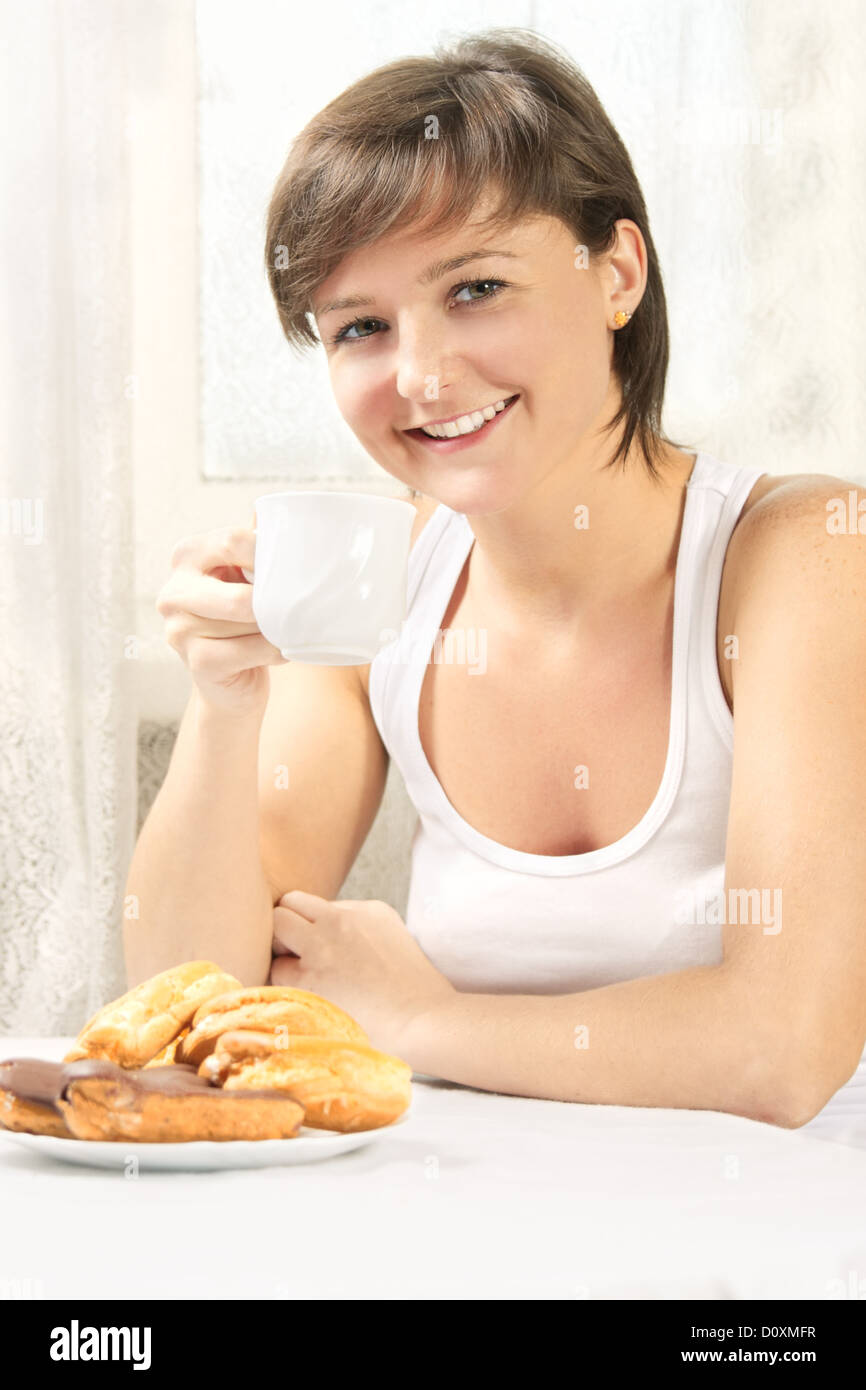 Smiling cute woman drinking tea with cakes Stock Photo - Alamy