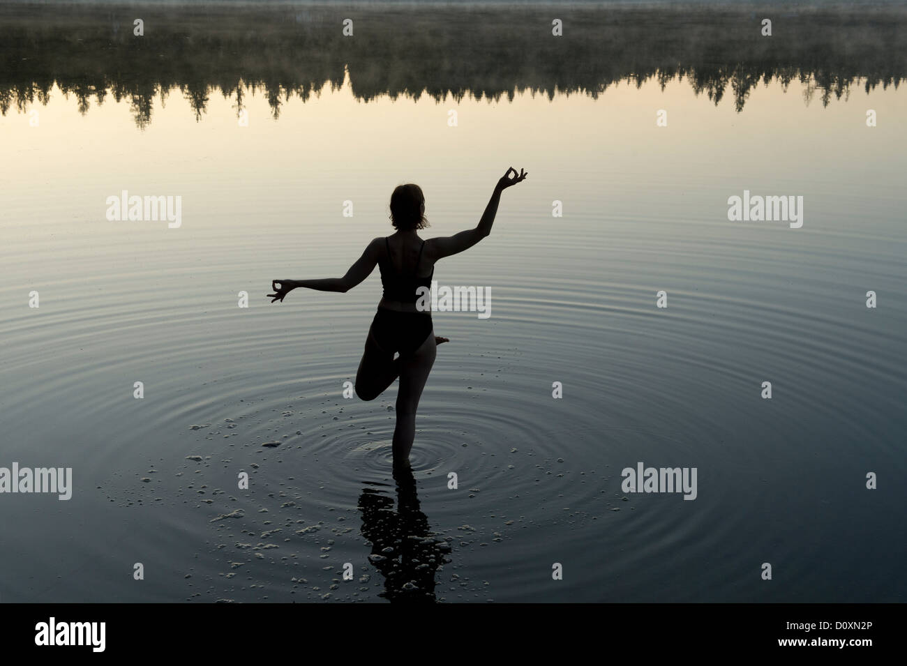 Woman in yoga pose in lake Stock Photo - Alamy