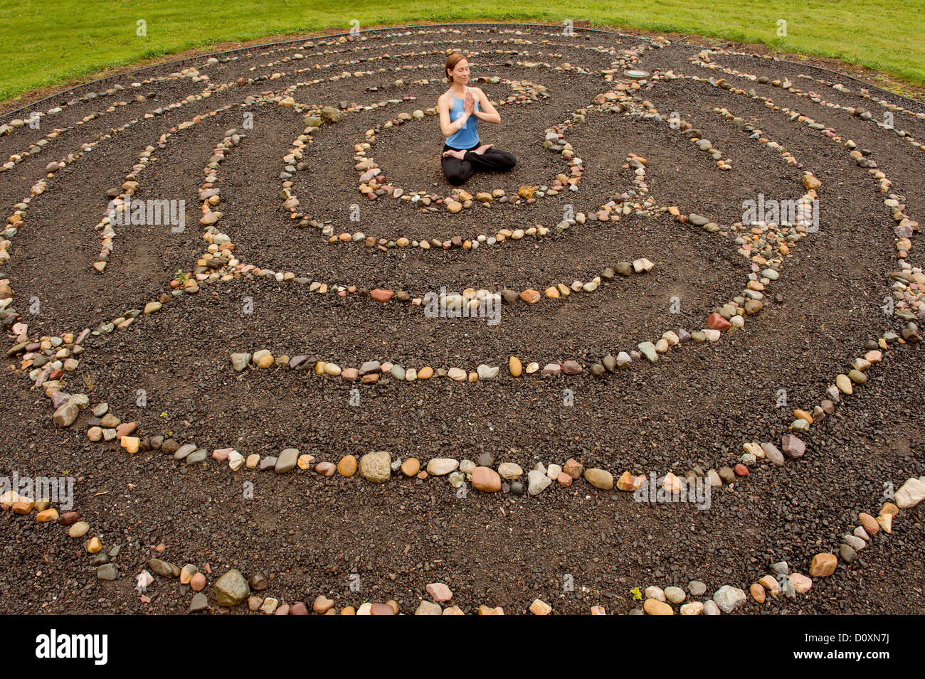 Woman meditating in stone labyrinth Stock Photo - Alamy