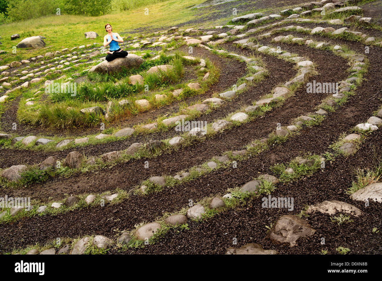 Woman meditating in stone labyrinth Stock Photo - Alamy