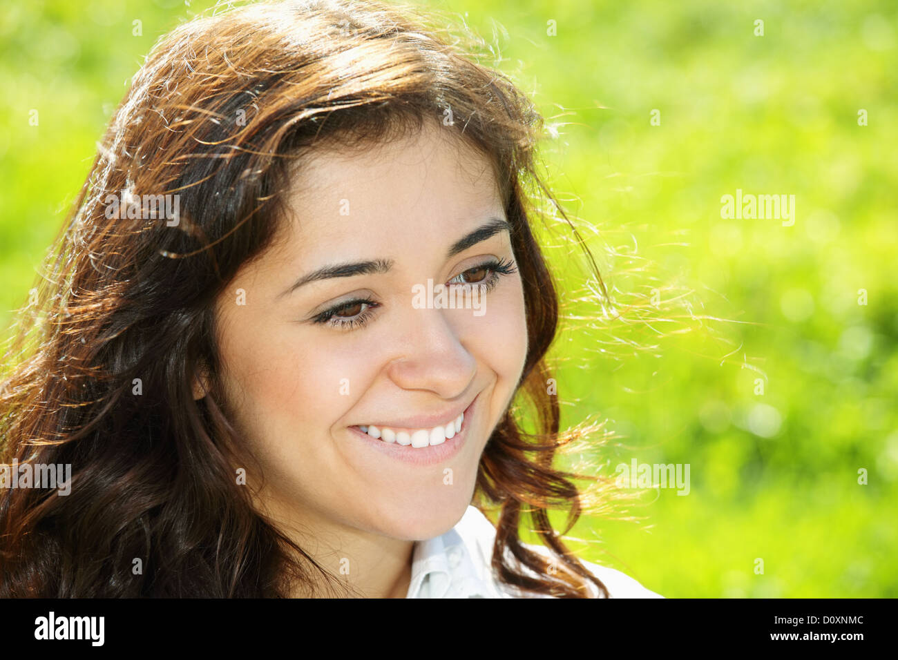Young smiling brunette looking sideways Stock Photo - Alamy