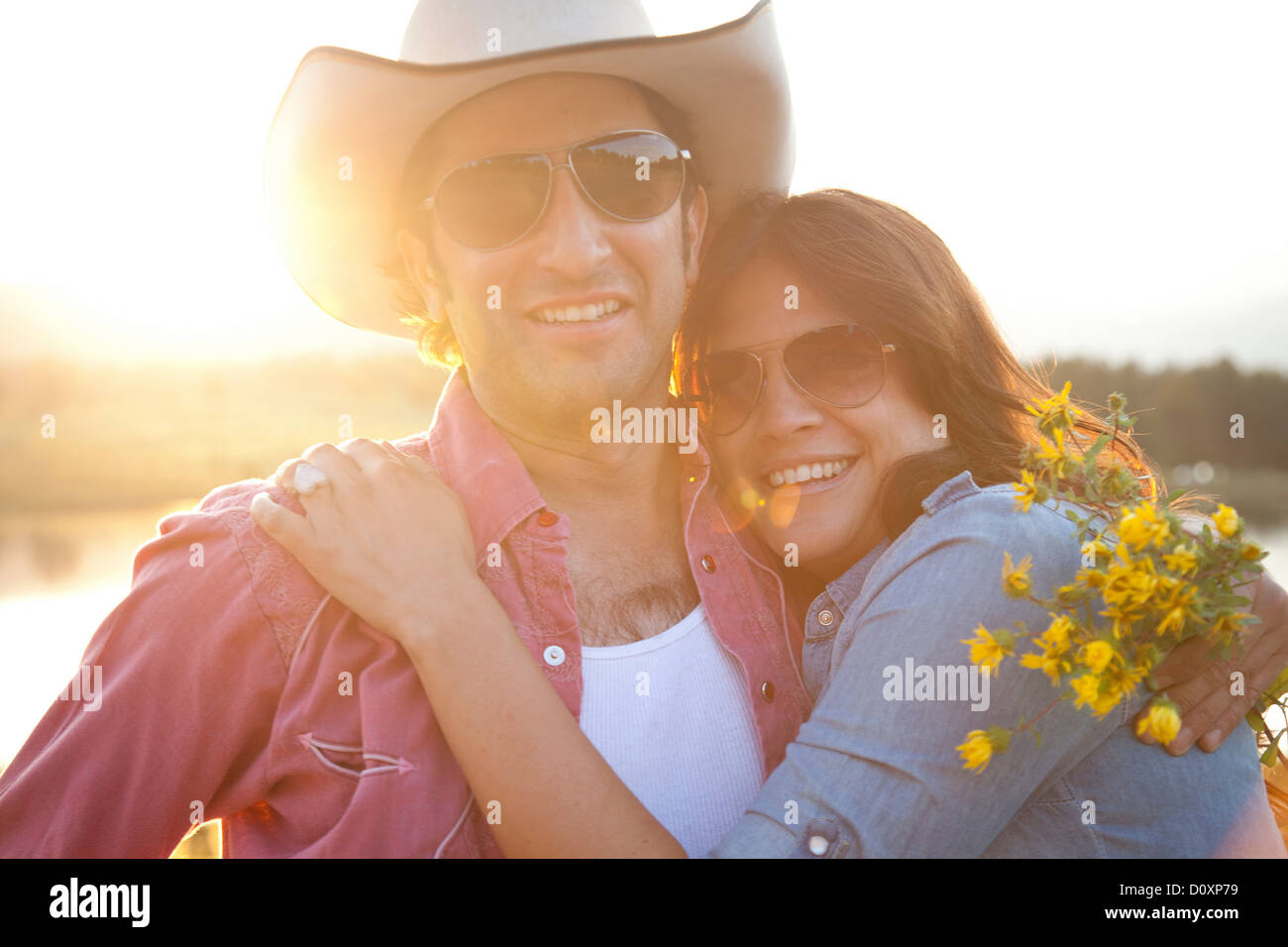 Happy couple in sunlight with flowers Stock Photo - Alamy