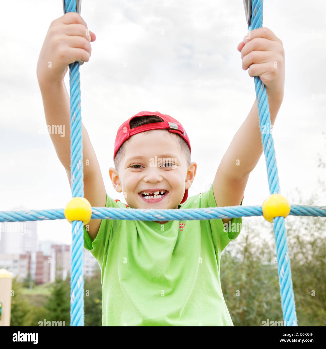 Smiling boy hanging on ropes Stock Photo - Alamy