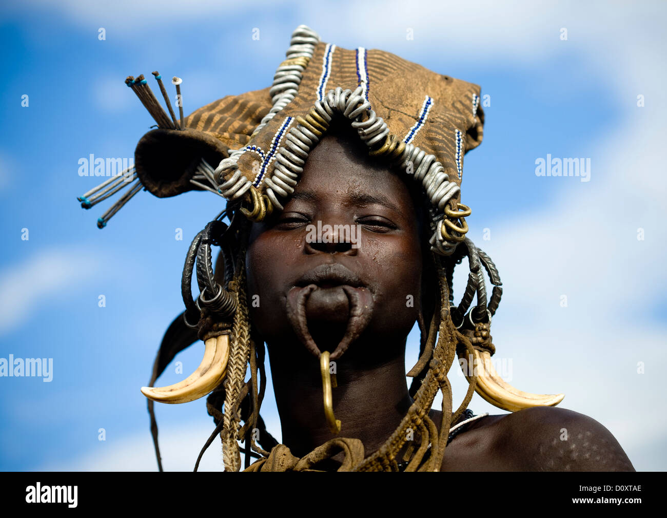 Portrait Of A Smiling Mursi Tribe Woman With Warthog Tusks As Earrings ...