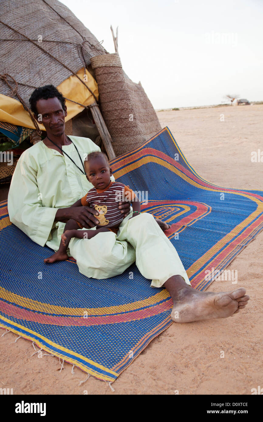 Tuareg man and his child in front of a traditional Tuareg tent near ...