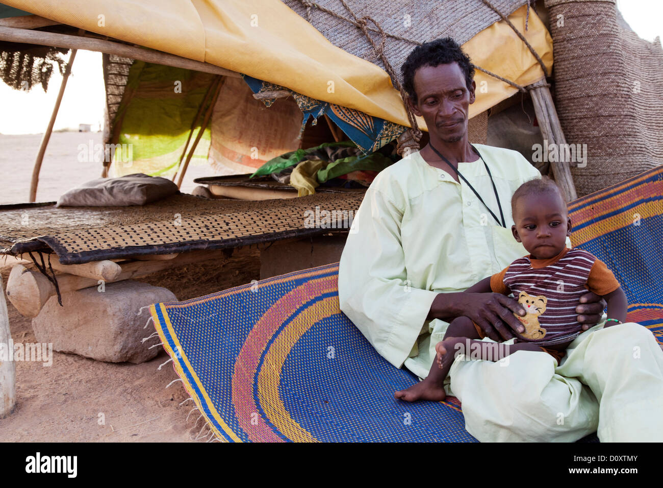 Tuareg man and his child in front of a traditional Tuareg tent near ...
