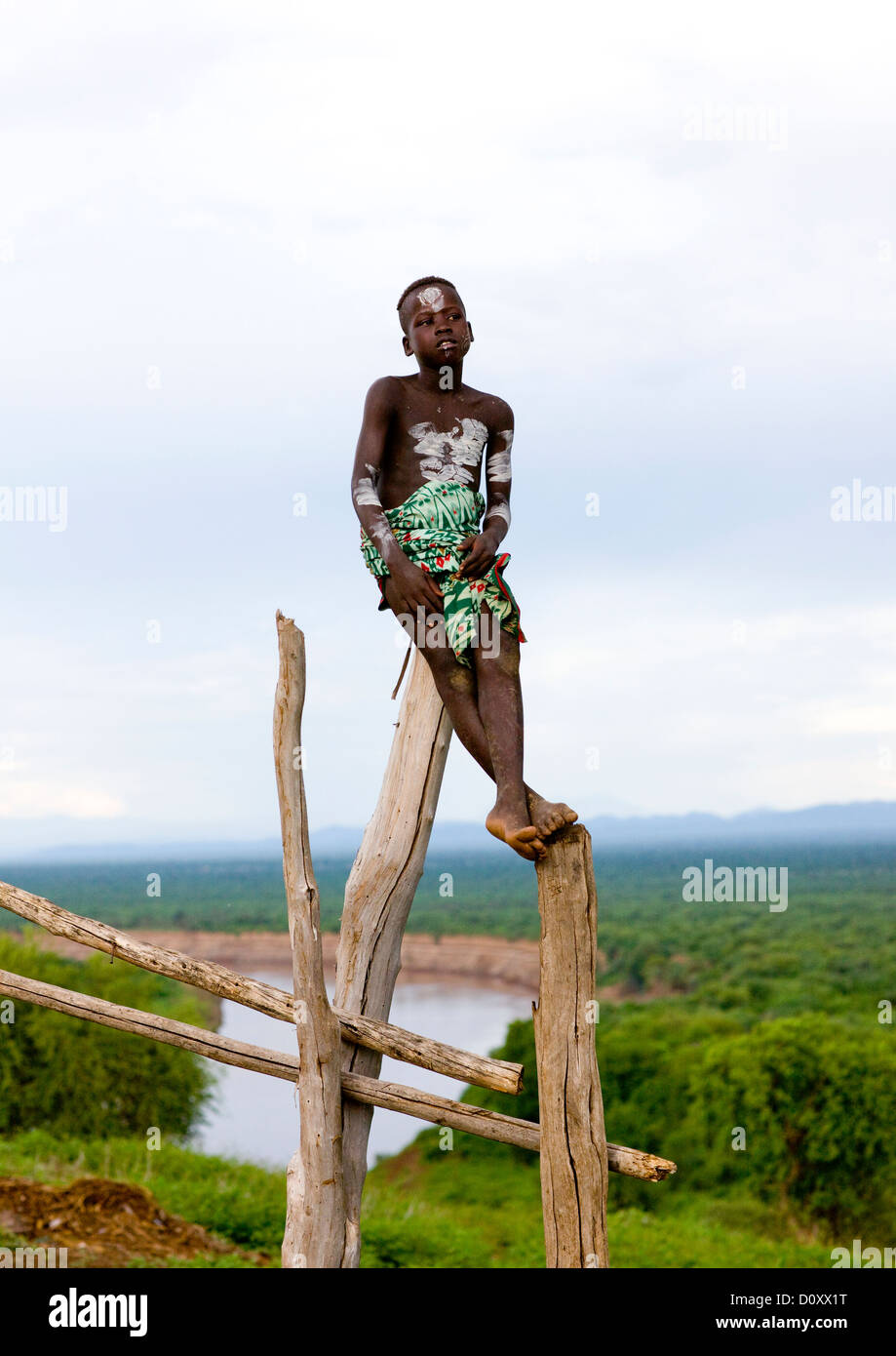 Portrait Of A Karo Tribe Kid With Body Paint Climbed On A Fence Over ...