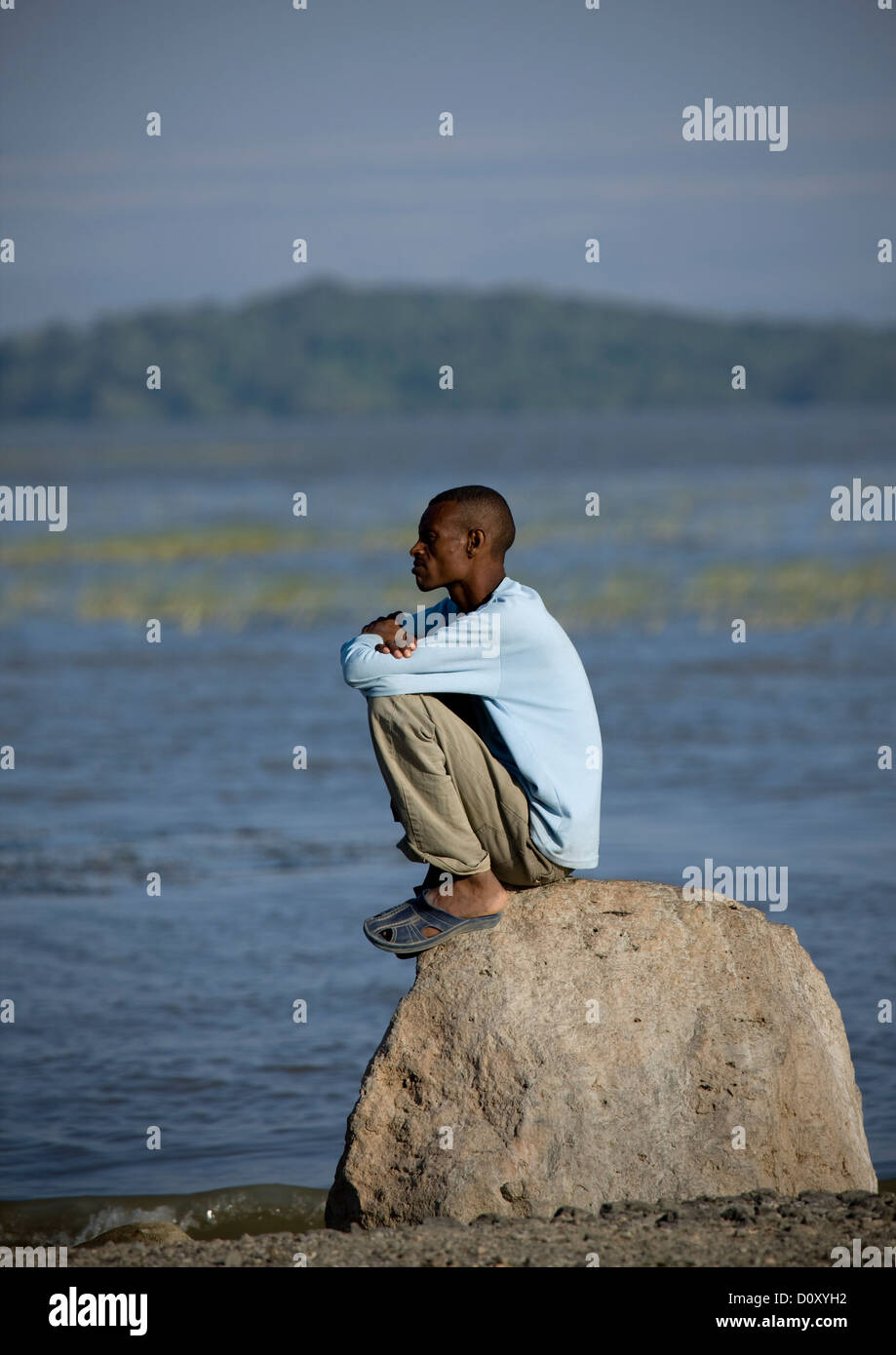 Oromo Man Sitting Alone On A Rock, Chamo Lake, Ethiopia Stock Photo - Alamy